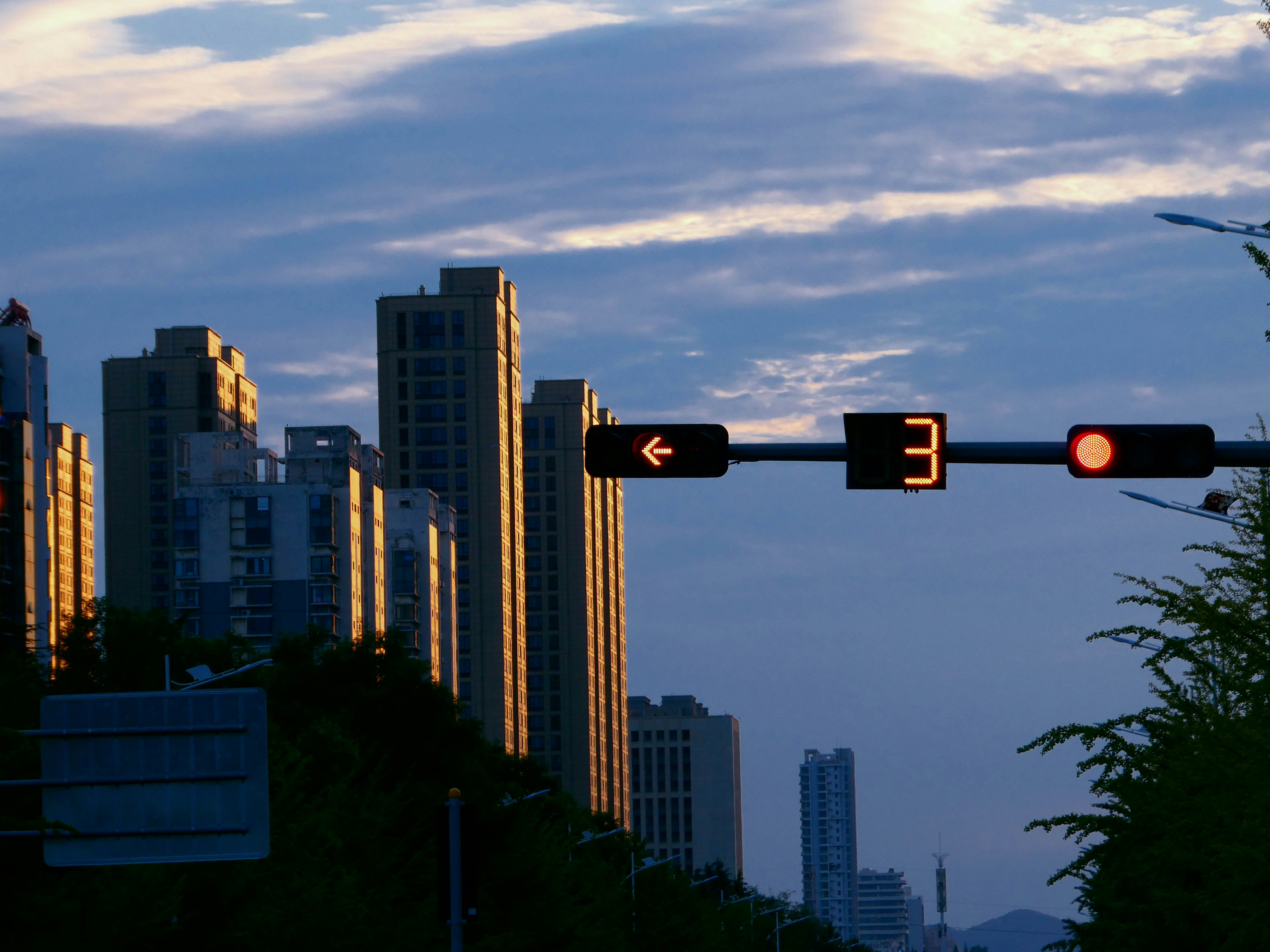Cityscape Signal: Golden Hour Beneath a Red Light