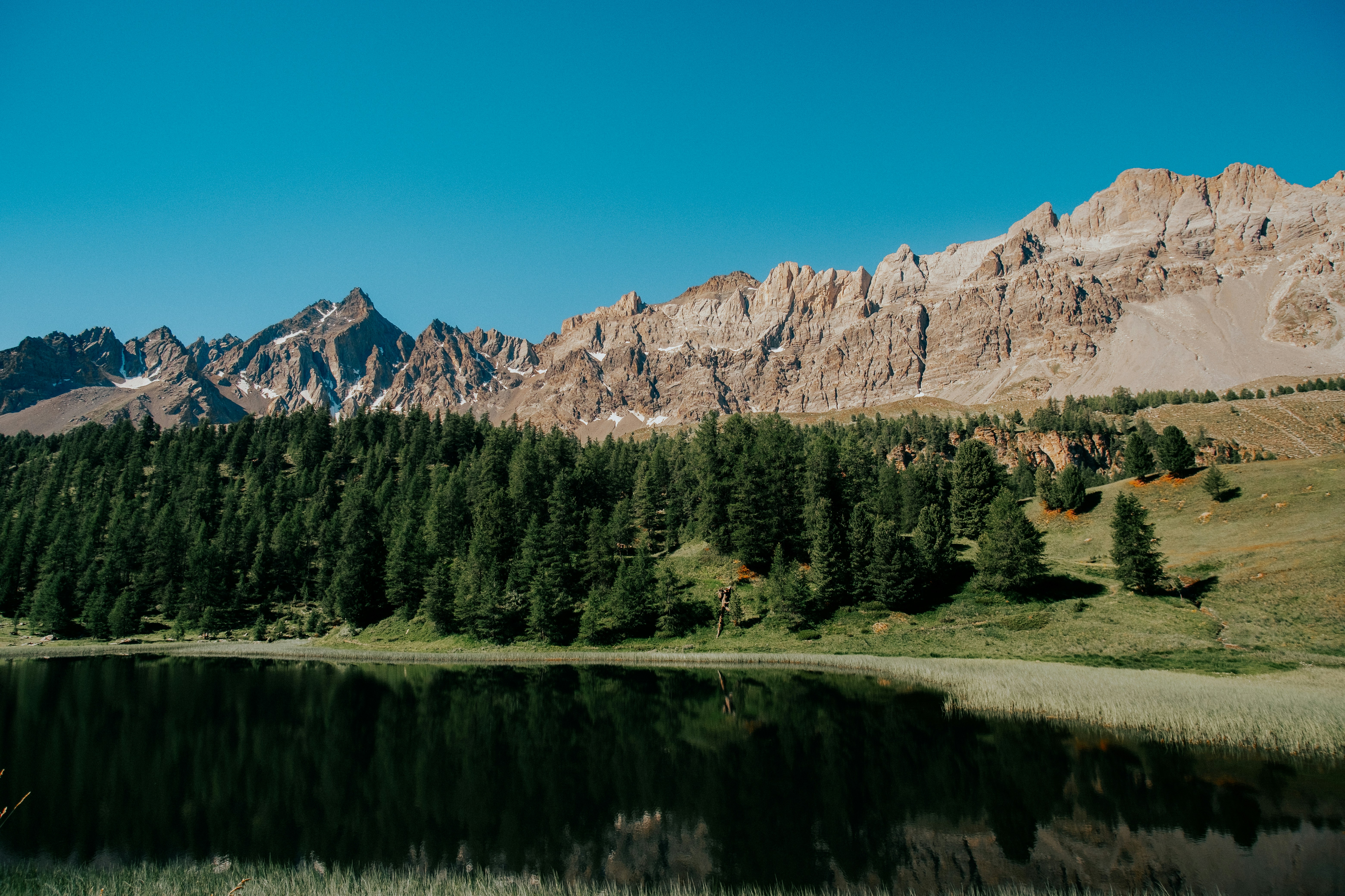 Serene Alpine Rim: Blue Sky Over Lake and Pine Ridge