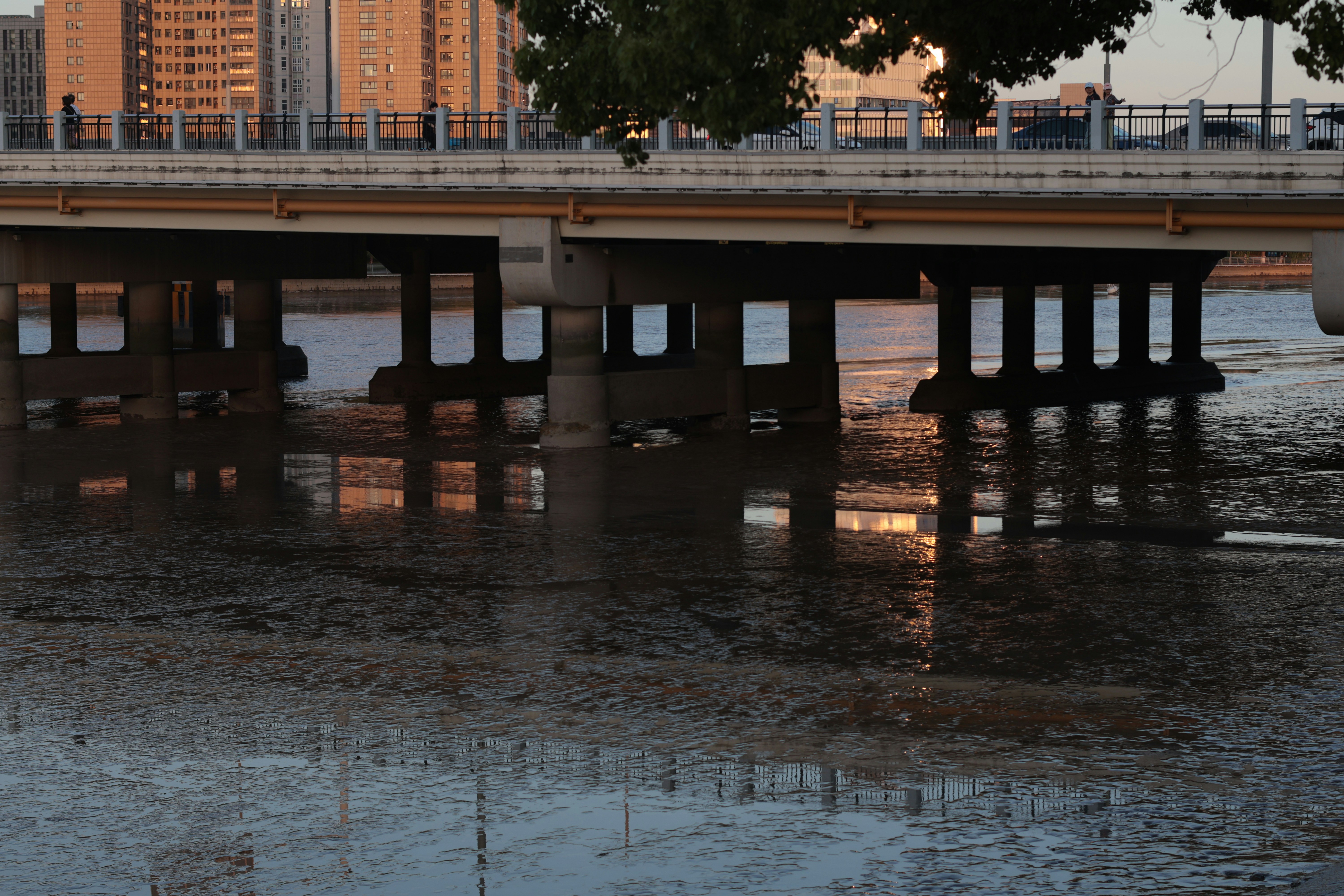 Golden Hour Bridge: Reflections and Pillars Over Calm Waters