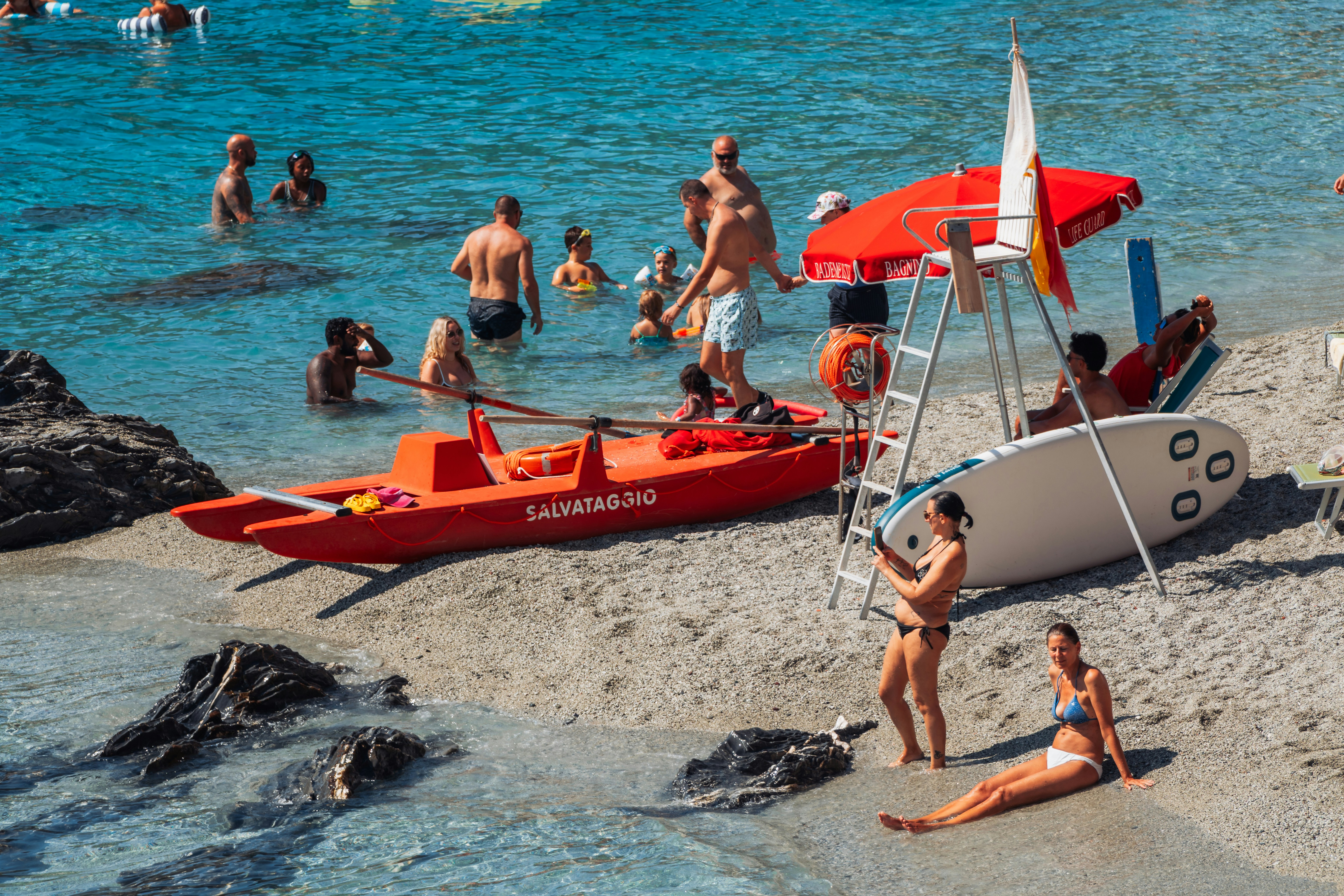 Orange RIBs and Sunlit Beach: A Busy Coastal Scene