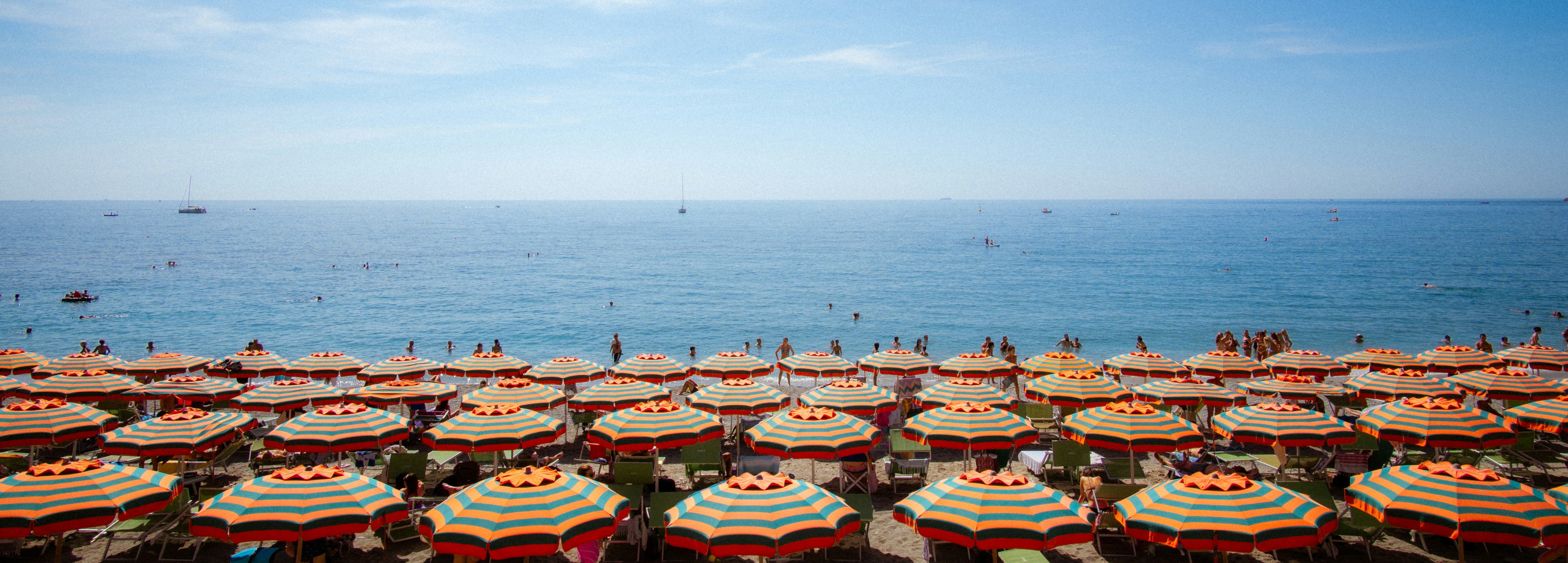 Sunlit Beach Ushering in a Sea of Parasol Stripes