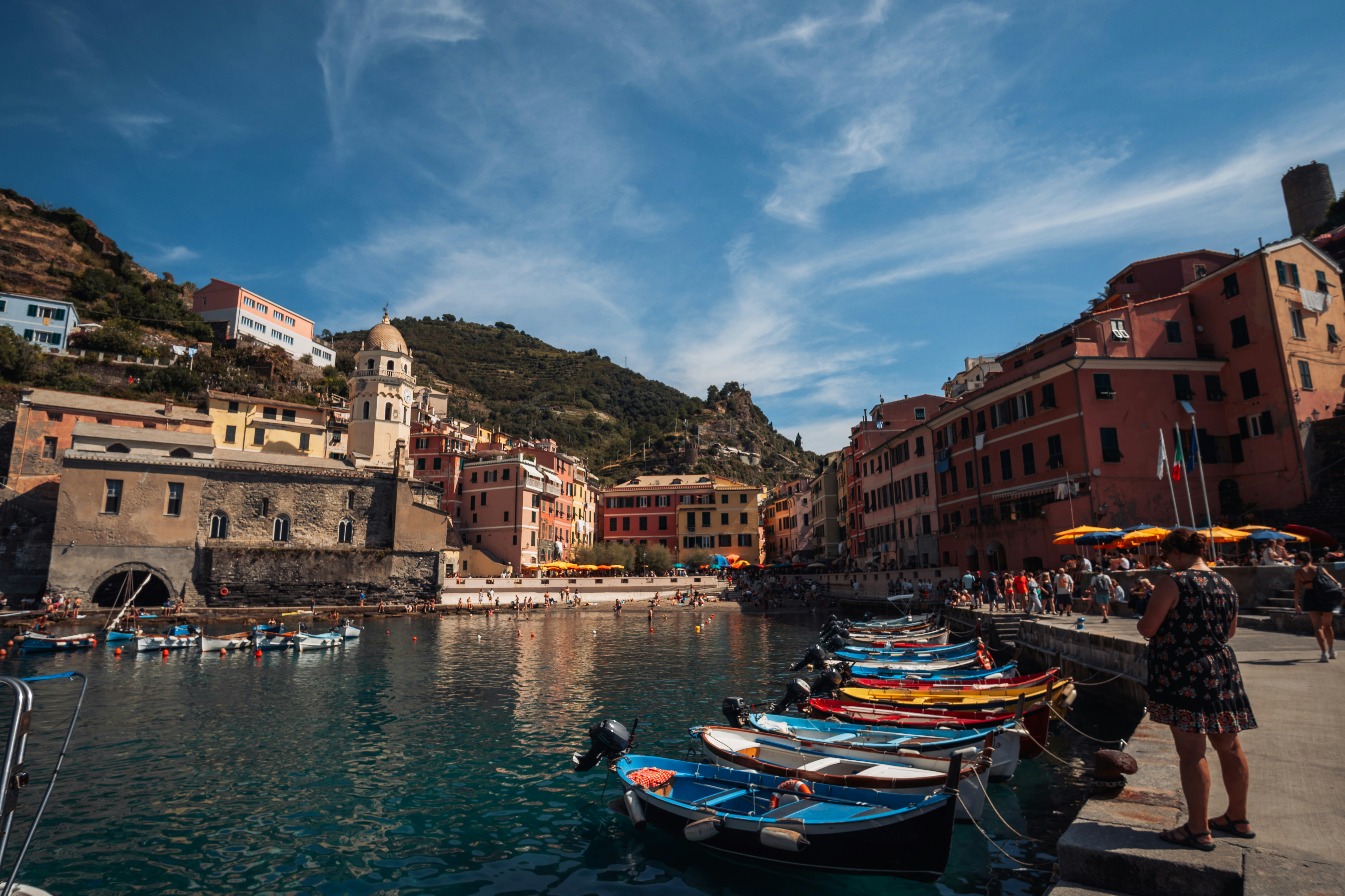 Colorful harbor village with anchored boats and sunlit waterfront