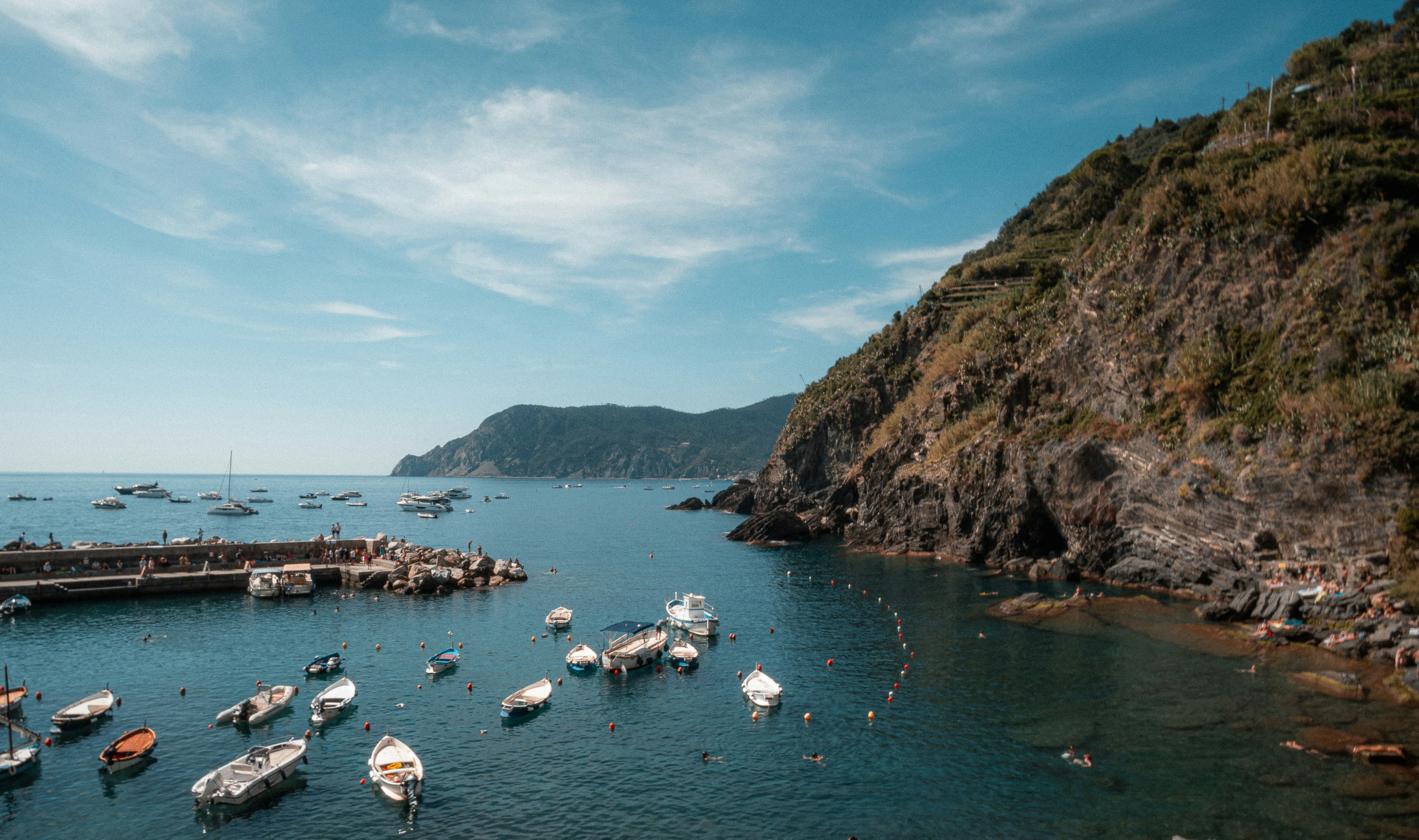 Harbor Veil: Boats at the Foot of a Cliffed Bay