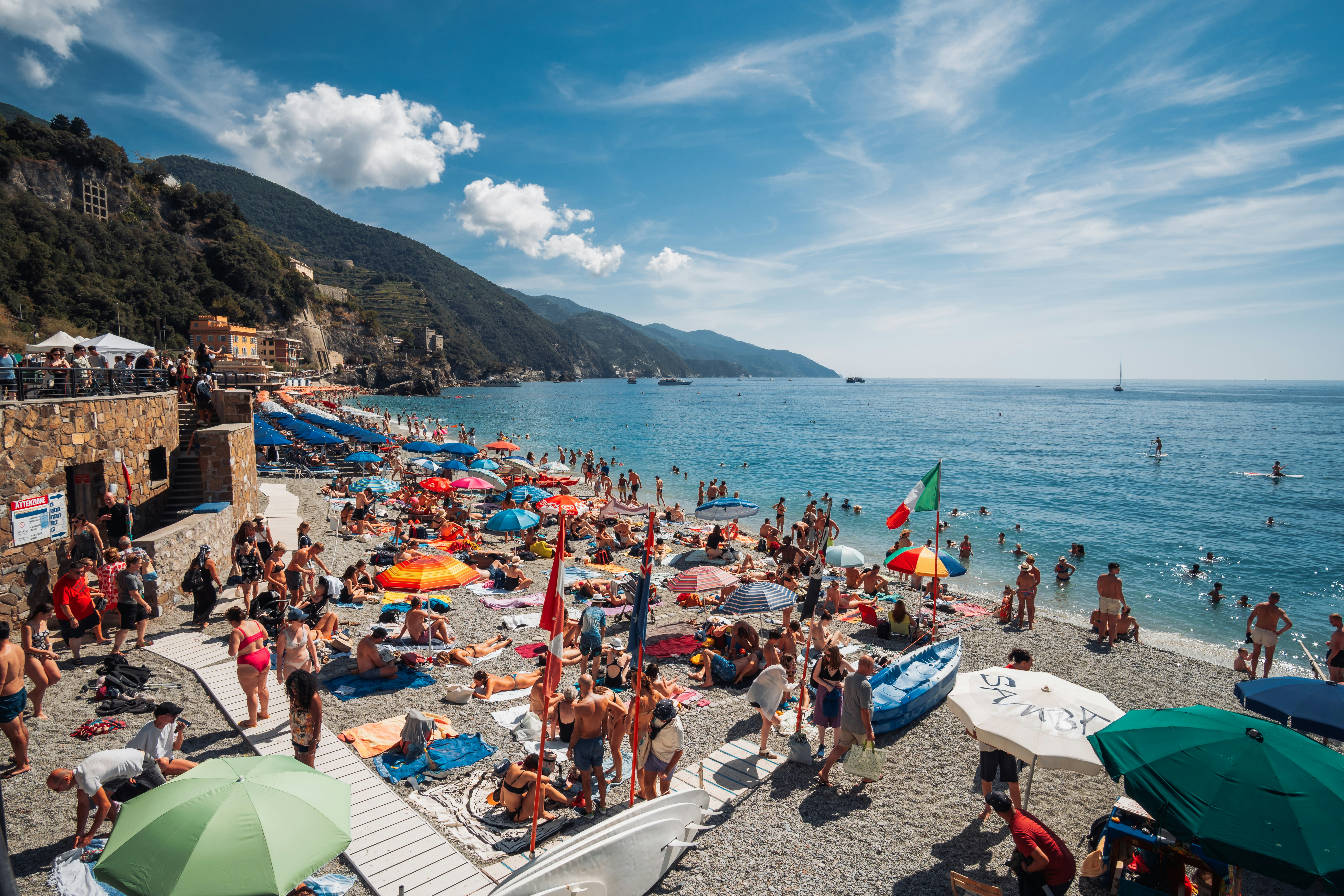 Sunlit Riviera: A Vibey Tangle of Beachgoers Under a Coastal Sky