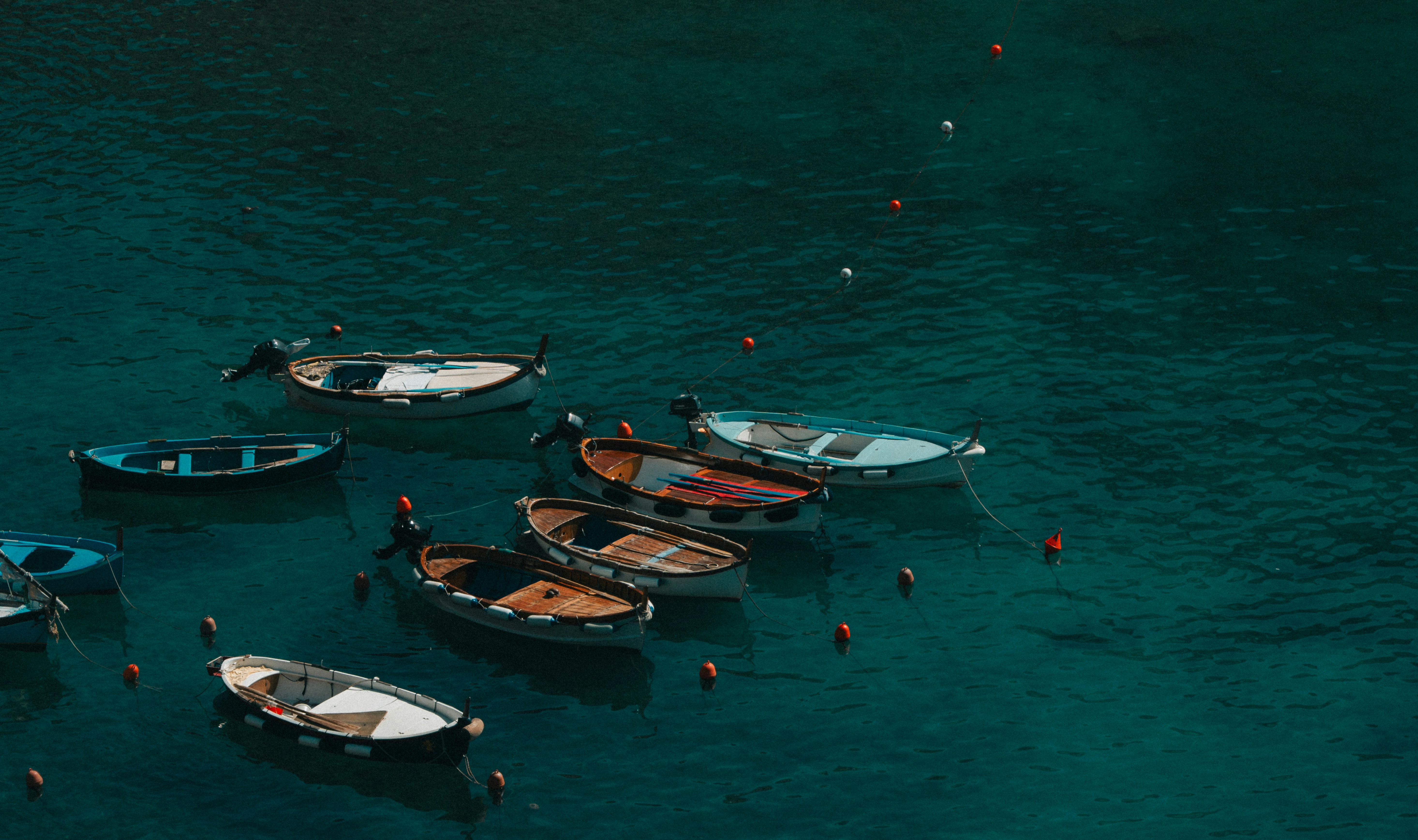 Turquoise Harbor: A Row of Boats Quietly Resting on Clear Waters