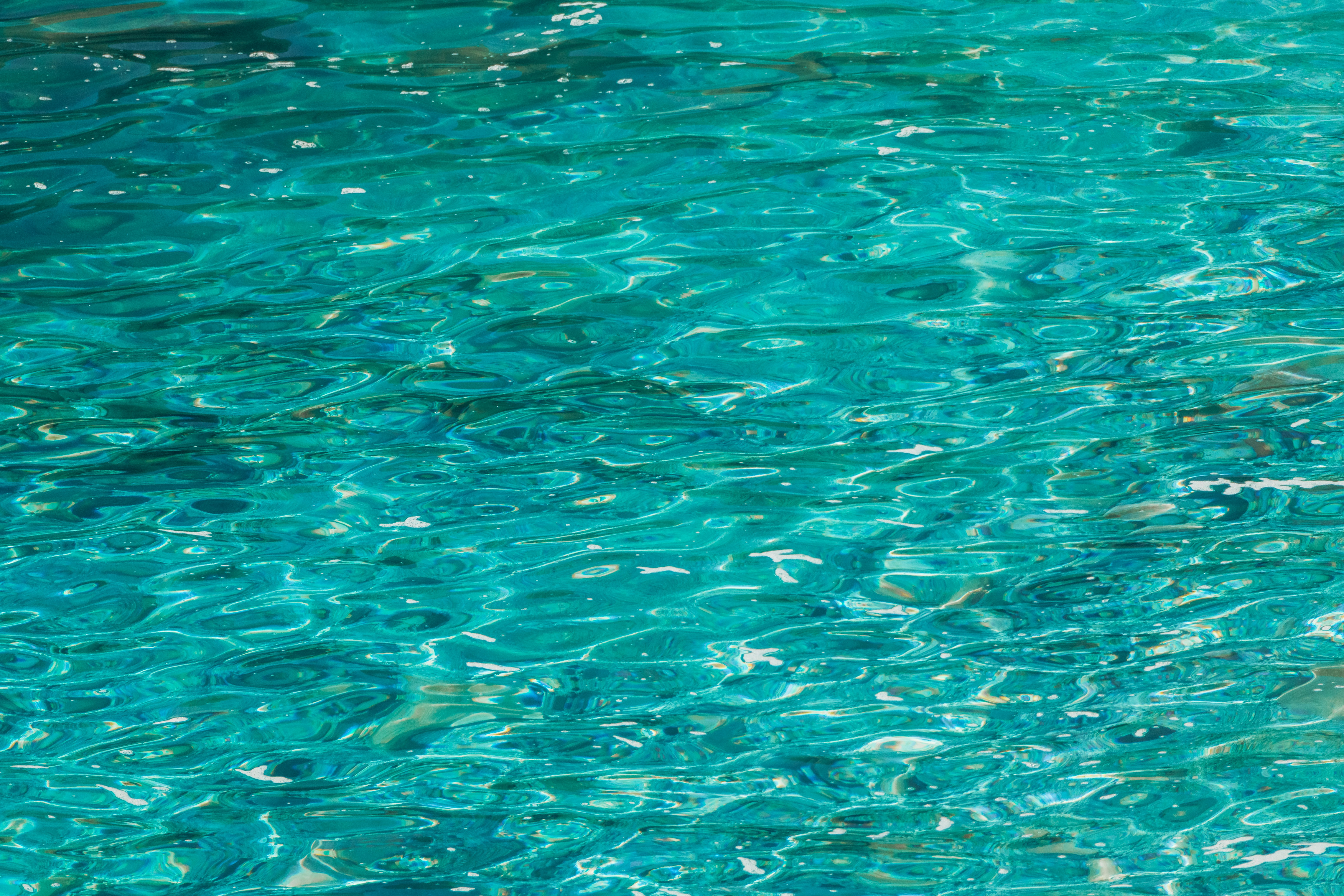Sunlit Ripples on Teal Pool Surface