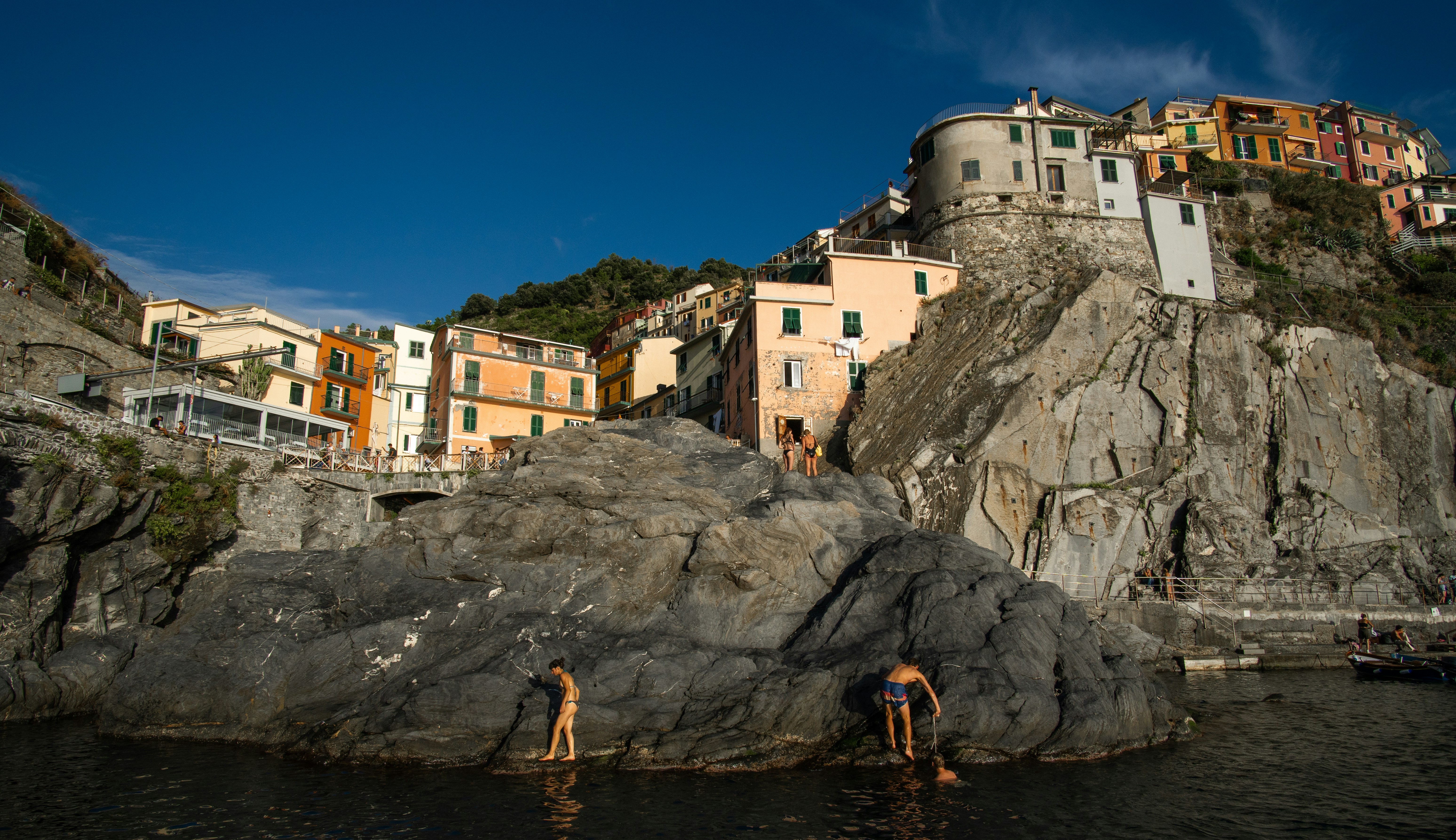 Cliffside Village at Dusk: People by the Rocks