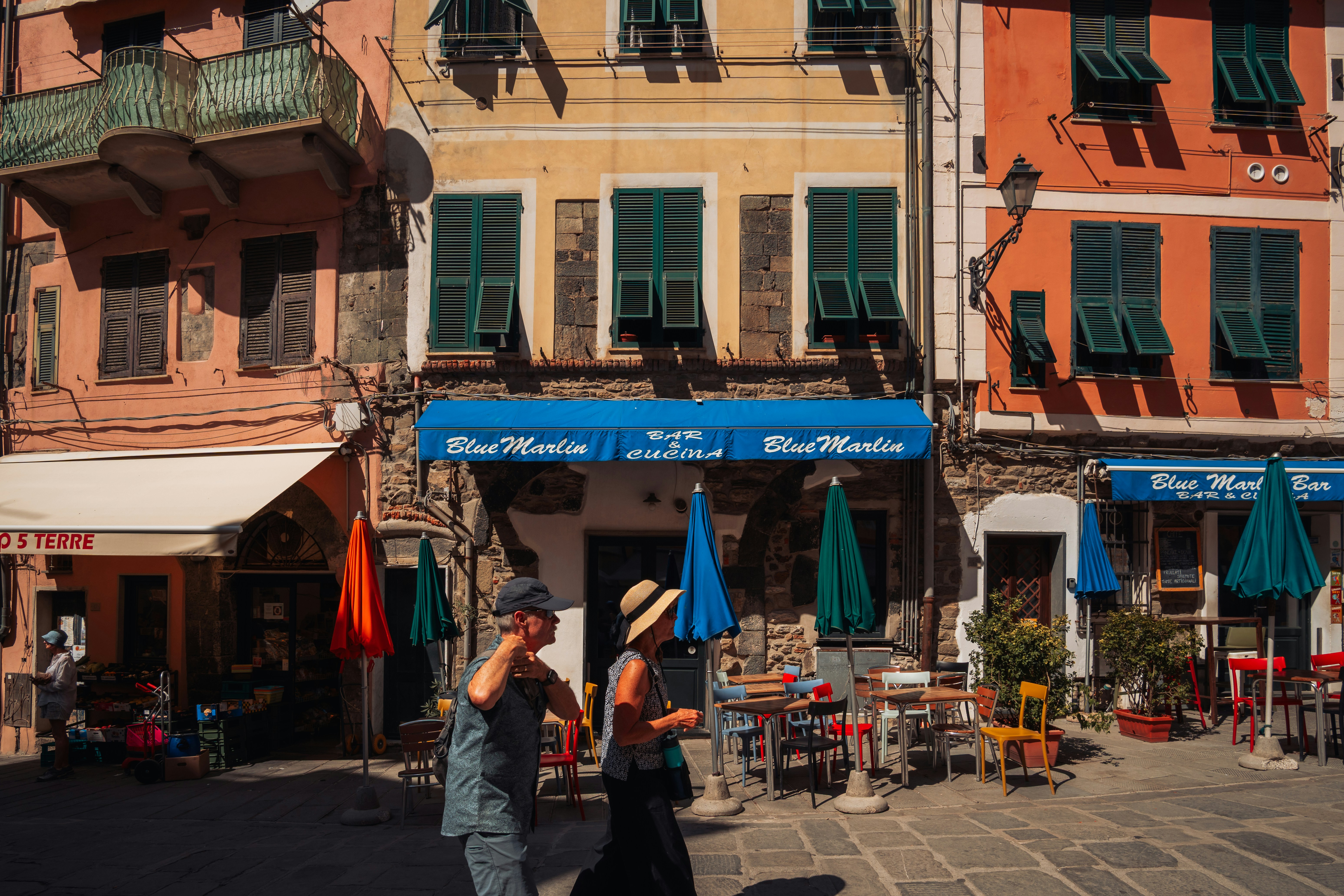 Sunlit Piazza: Café Facades and Shaded Struts