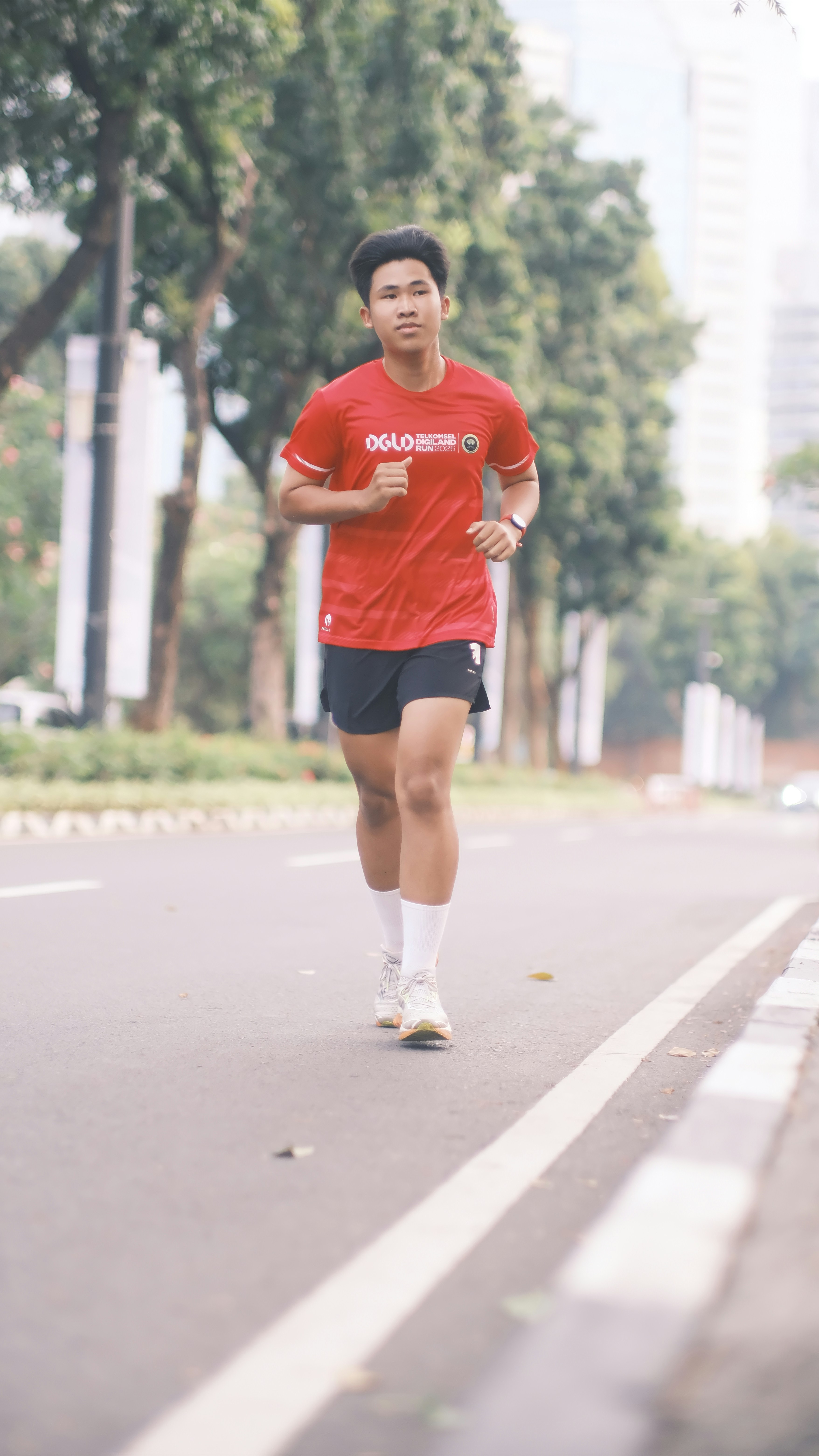Runner in Red Jersey Traverses an Urban Avenue