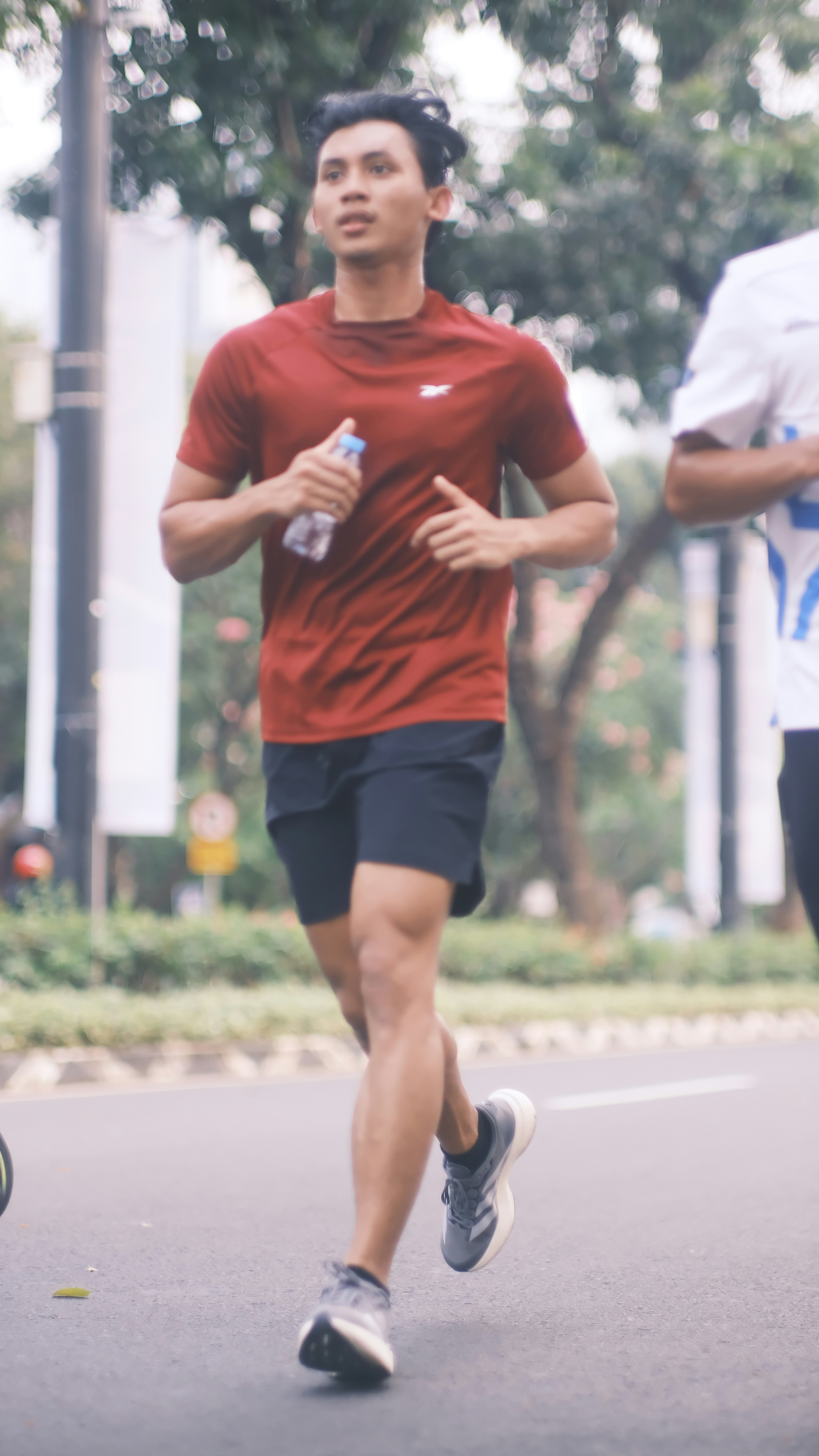 Stride Under City Lights: A Runner in Red Morning Pace