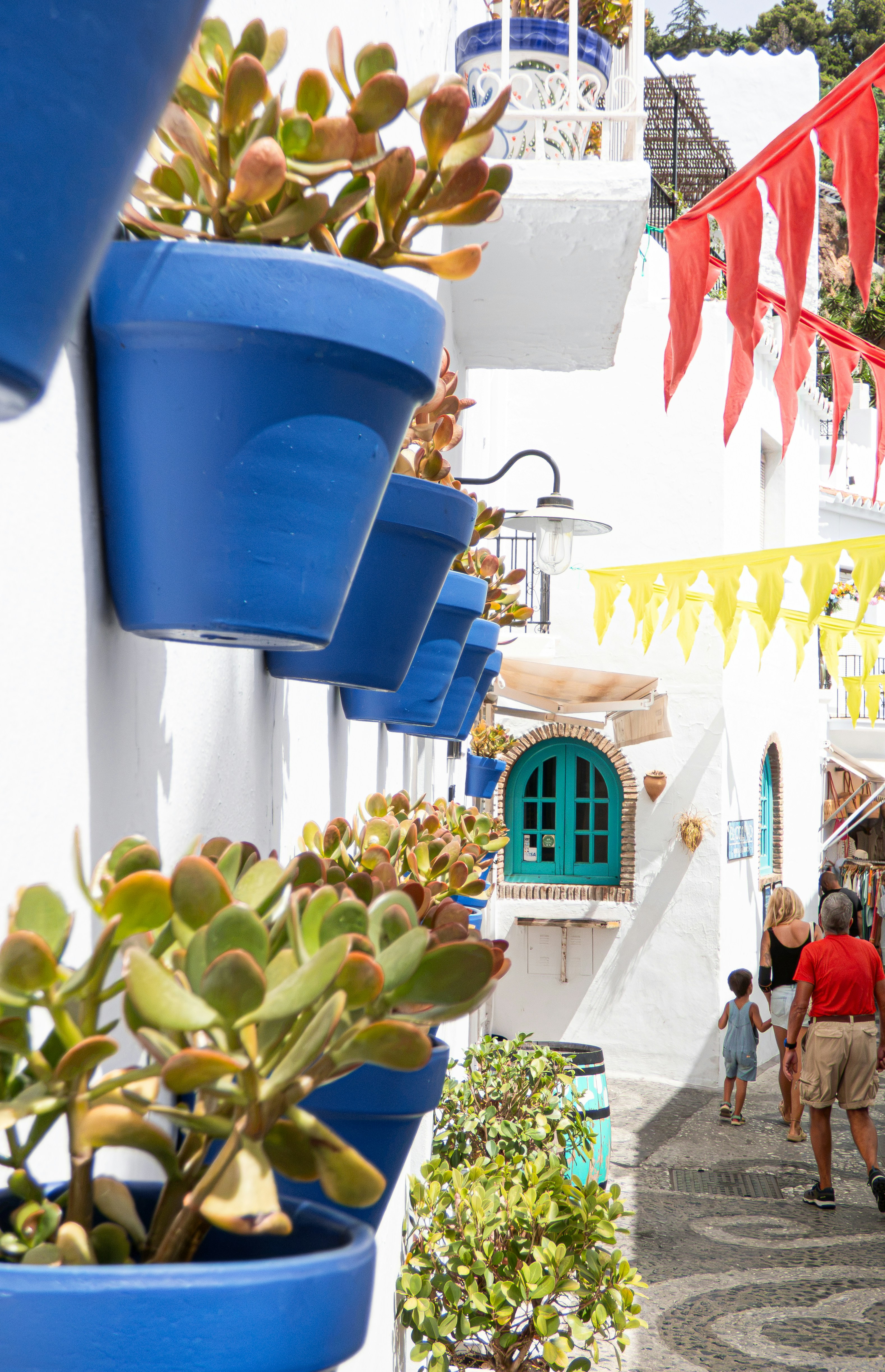 Blue Pots, White-Walled Street: A Burst of Color in a Mediterranean Alley