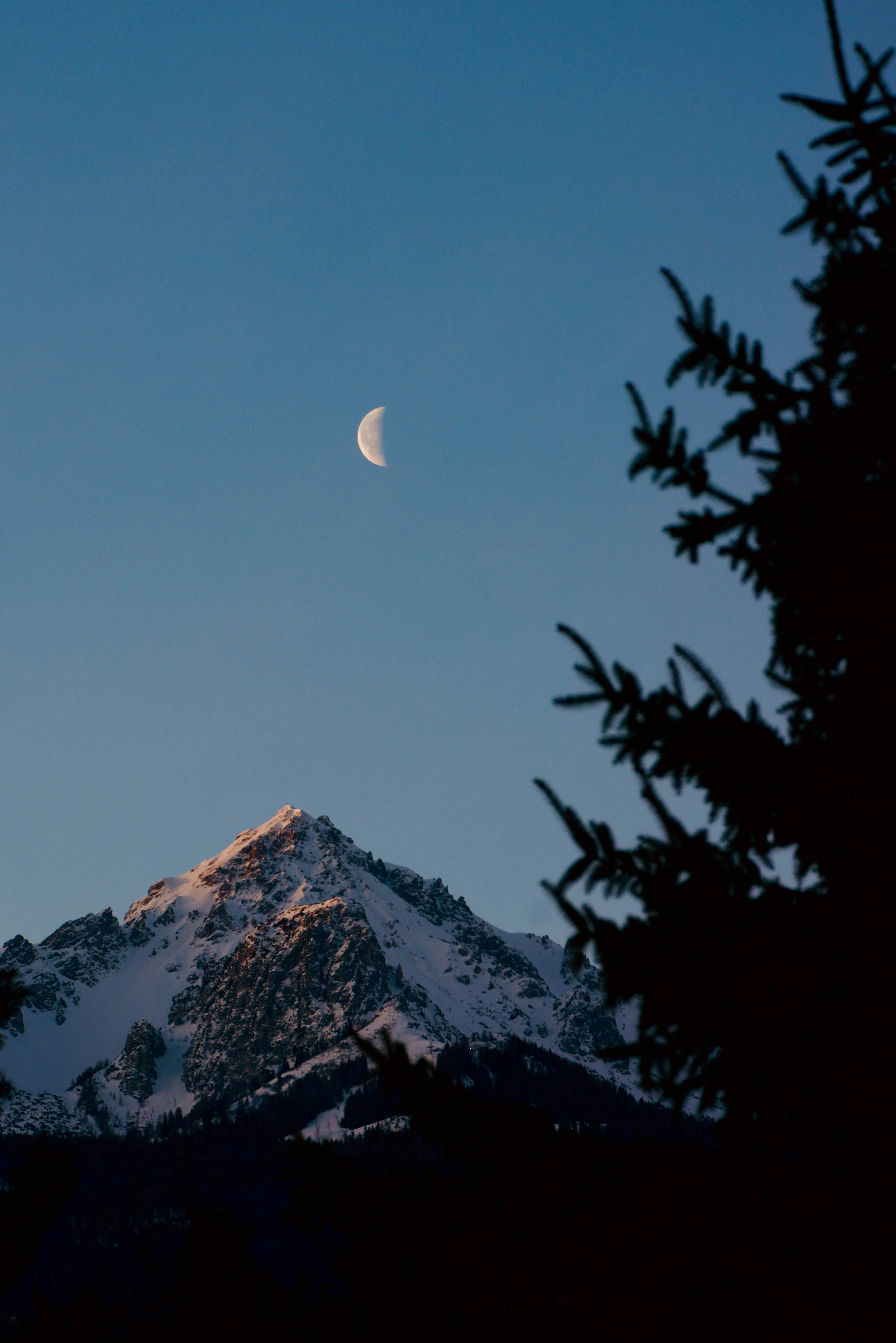Moonlit Peak: A Snow-kissed Summit Under a Crescent