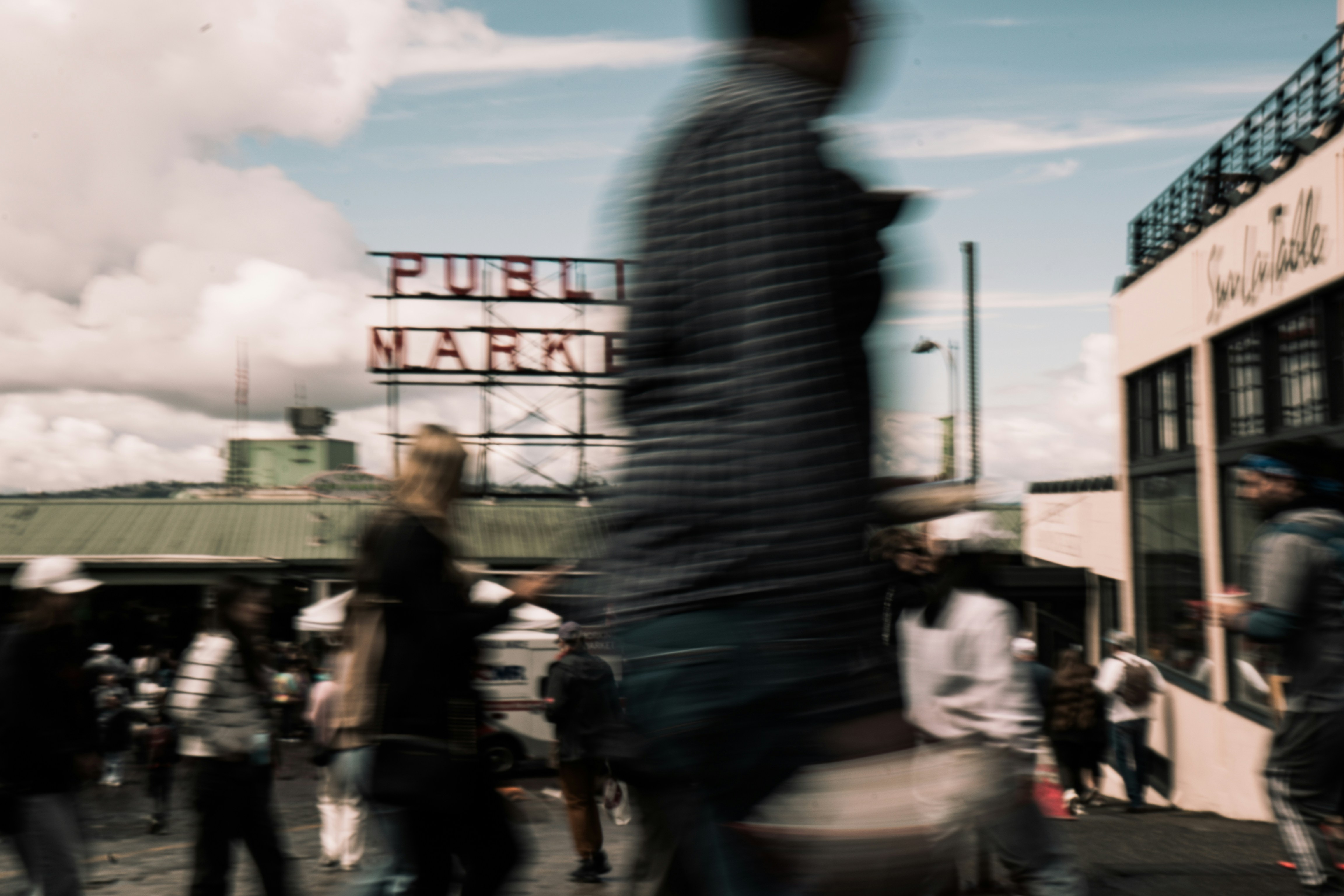 Crowd in Motion: Blurred Street Scene by a Marketfront