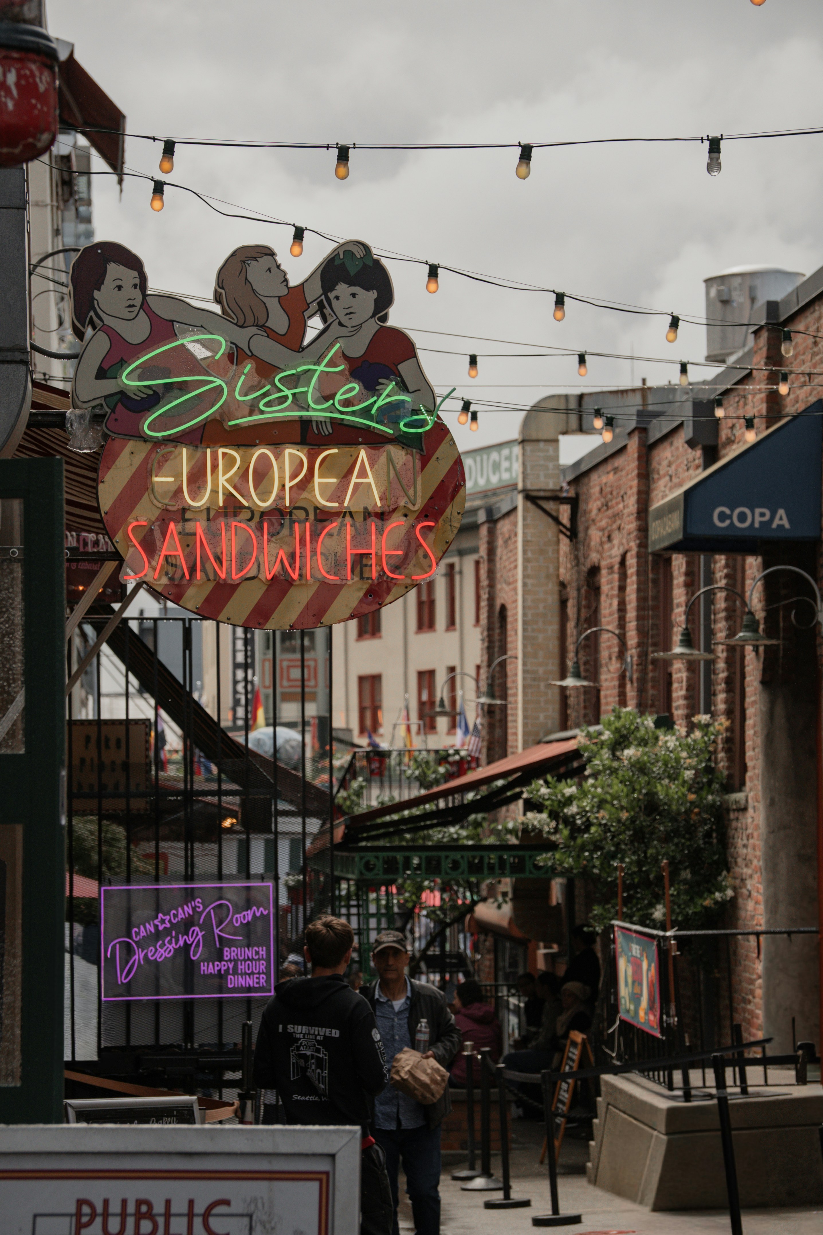 Neon Signage and Street Café in a Cozy Urban Alley