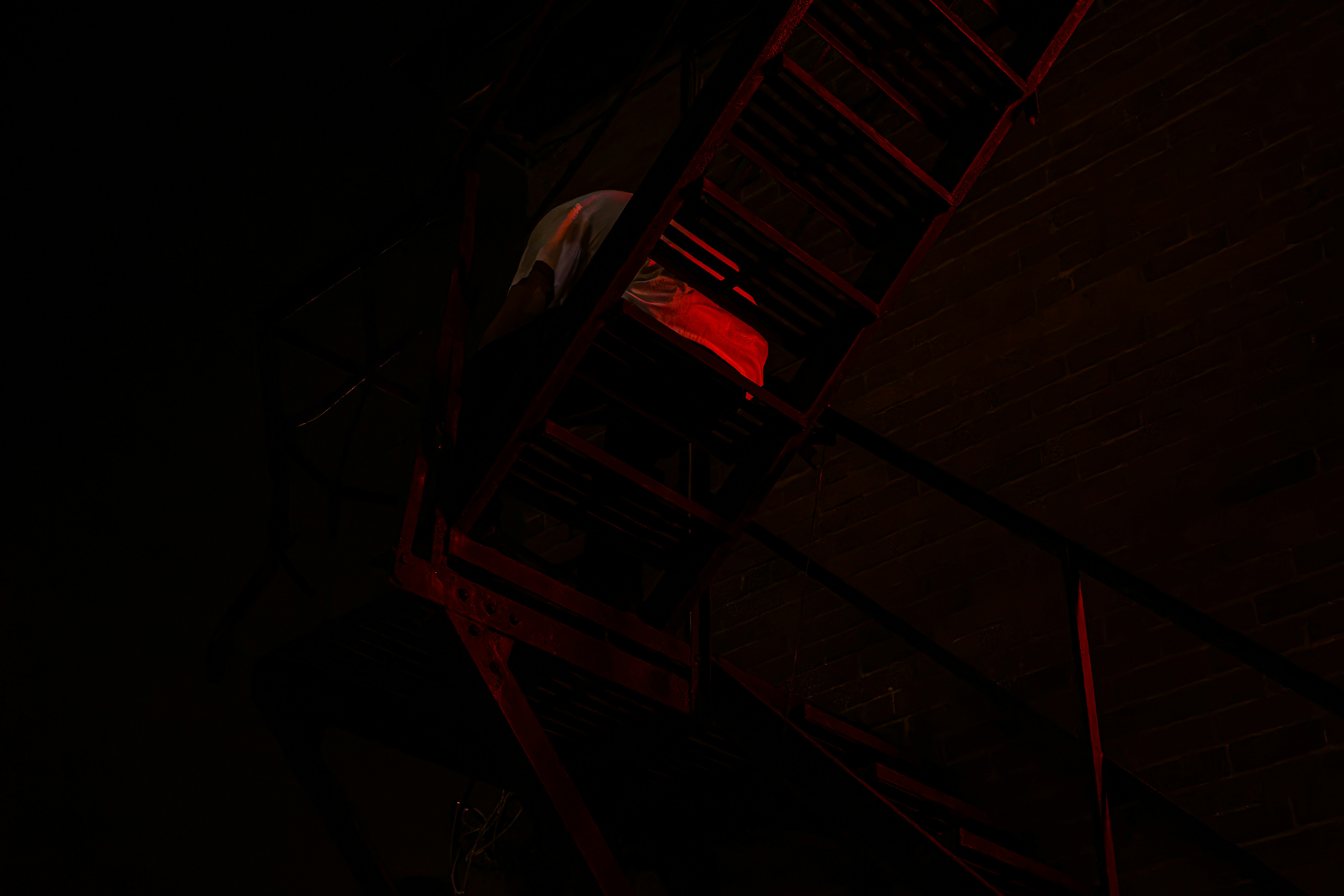 Hidden figure on a red-lit stairwell