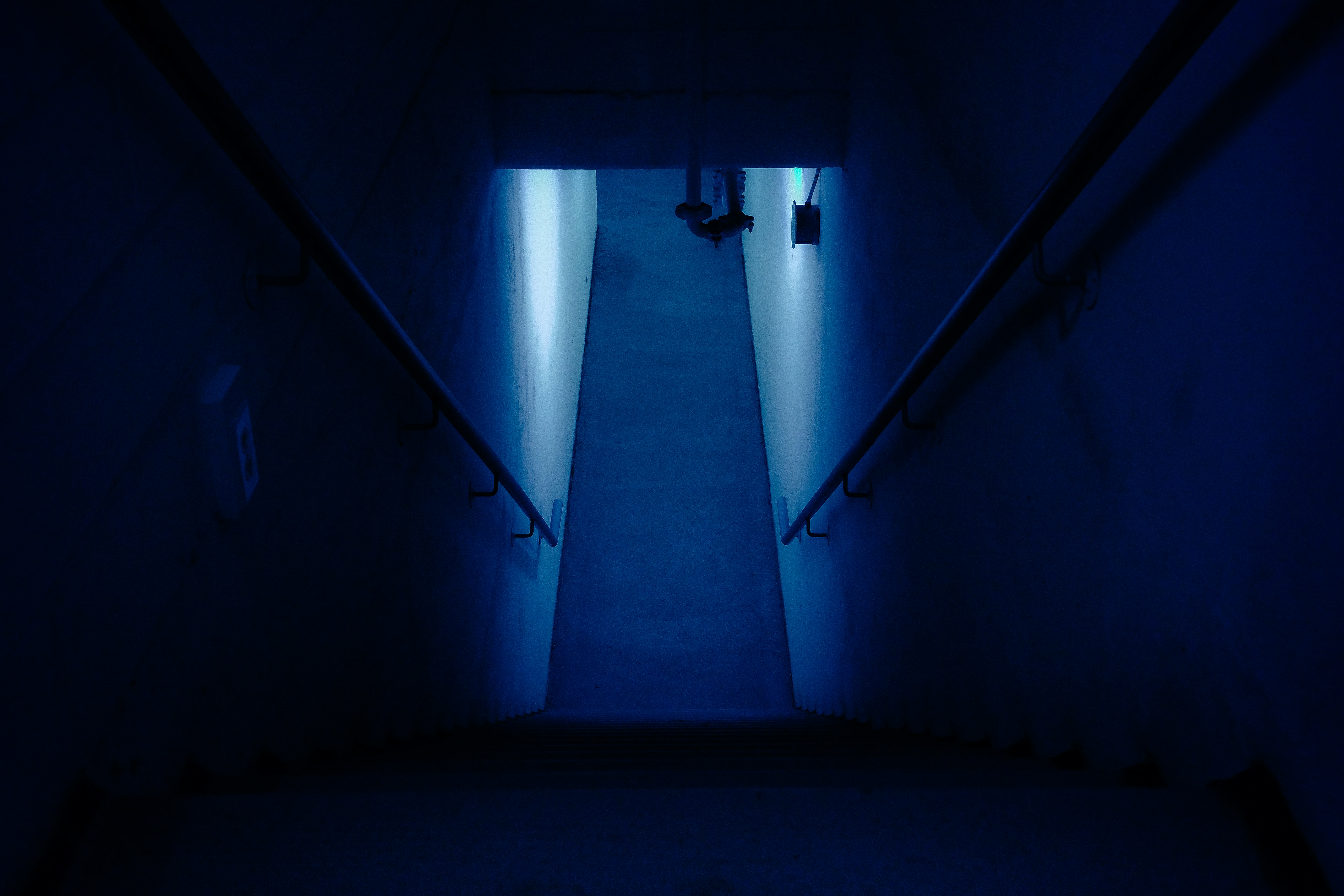 Blue Staircase to Light: A Quiet Descent into a Narrow Corridor