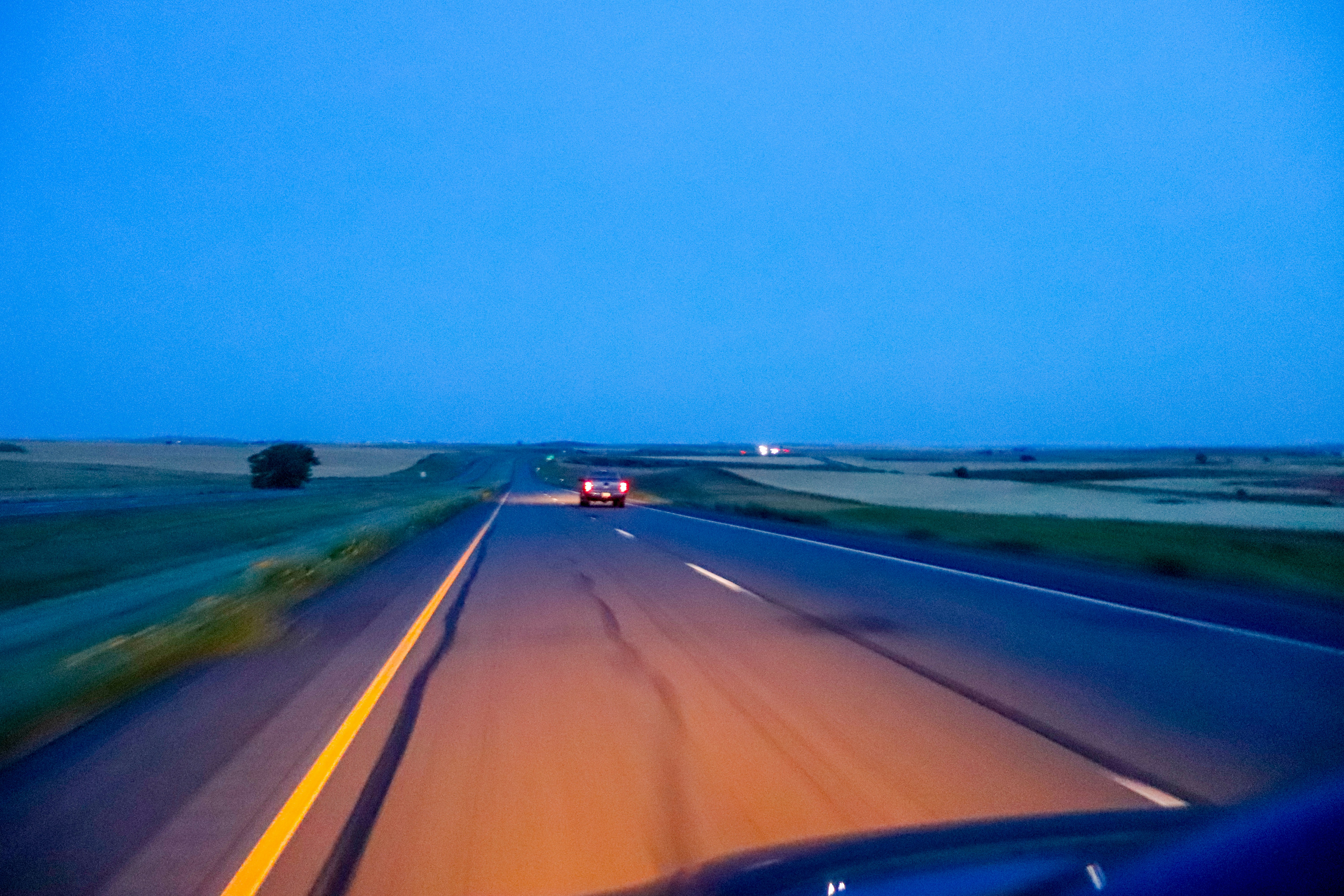 Distant Car on a Quiet Prairie Highway at Dusk