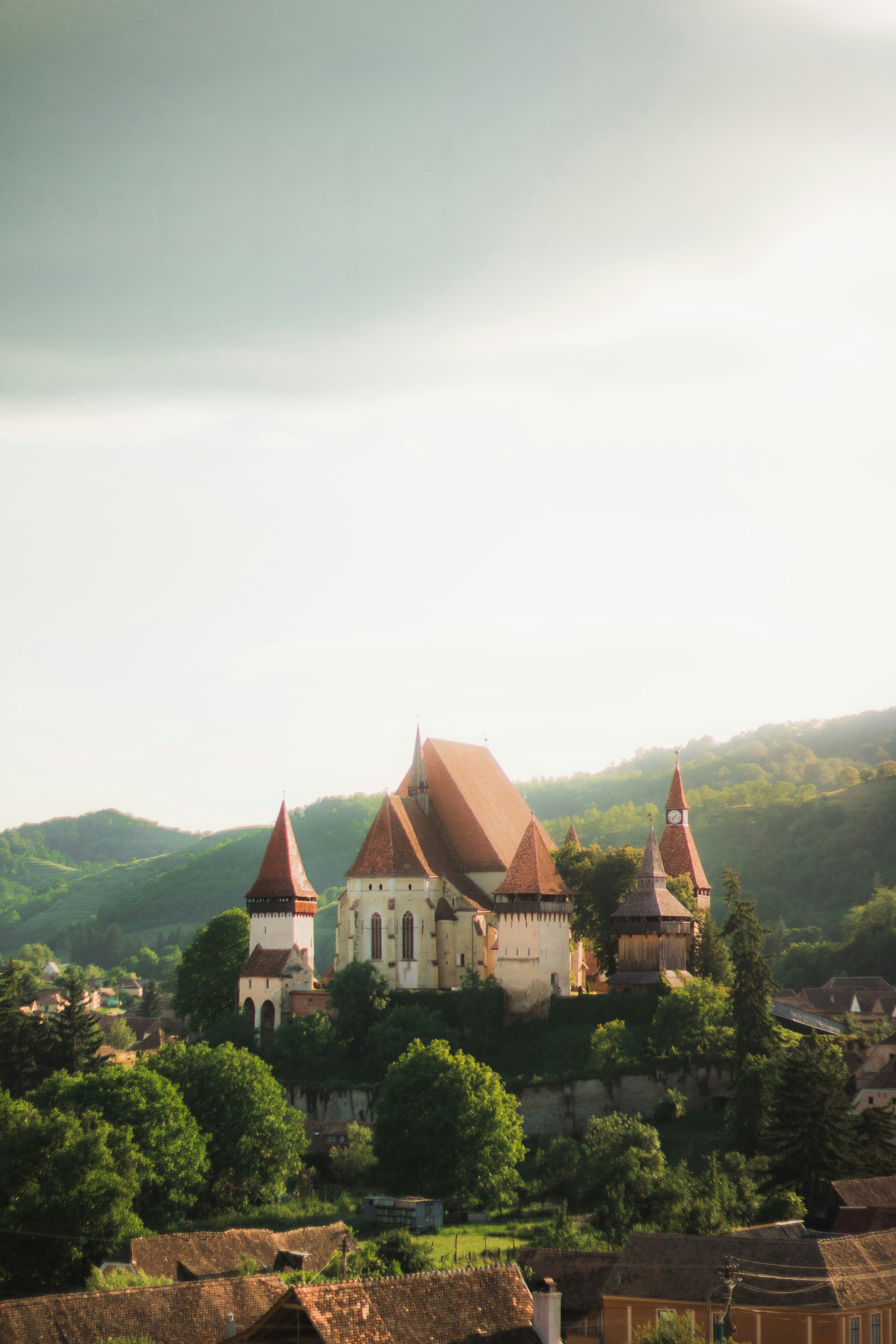 Stone Fortress Amid Green Hills Under Soft Evening Light