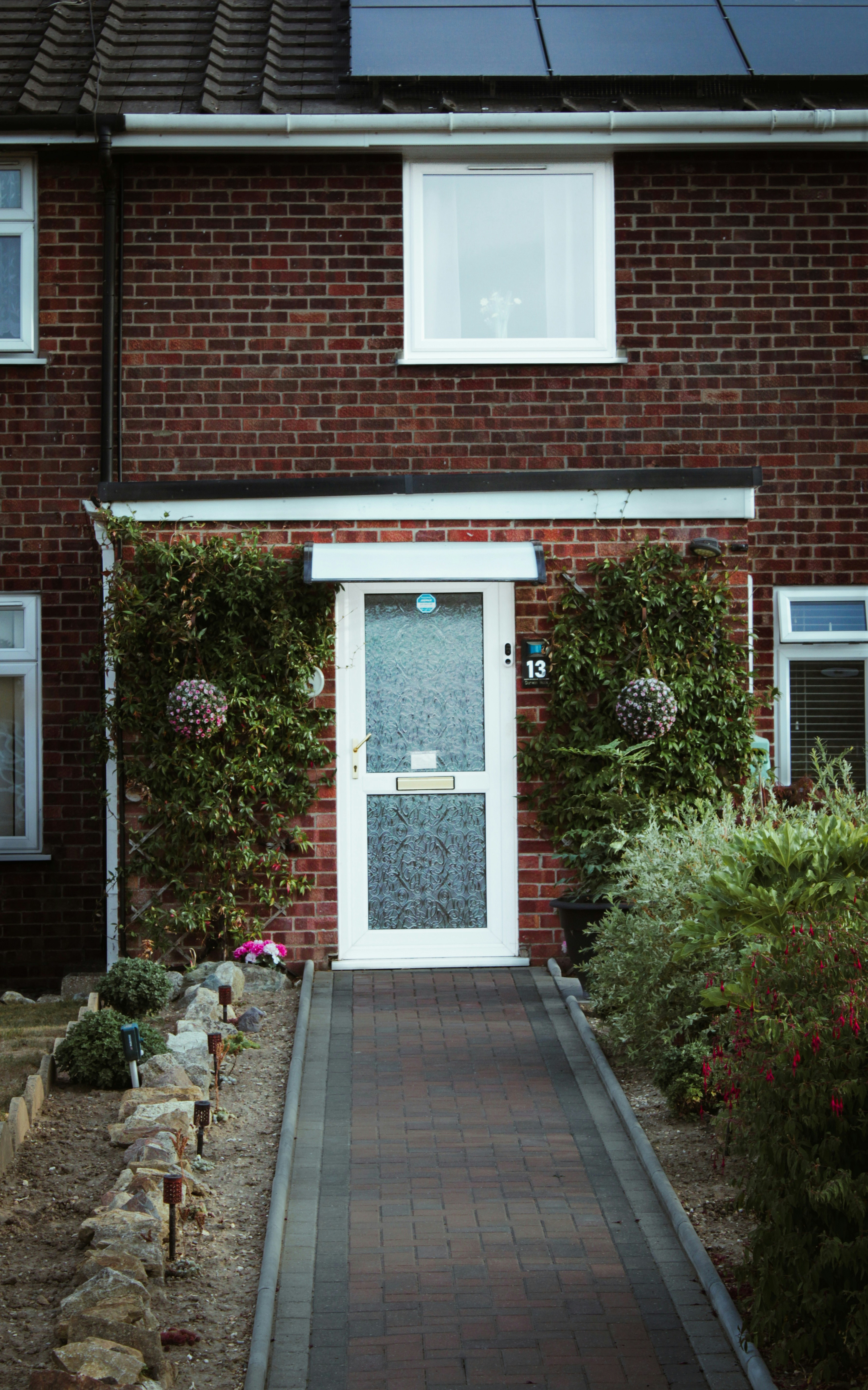 Front Door in a Brick Terrace: A Welcoming Pathway to the White-Trimmed Entrance