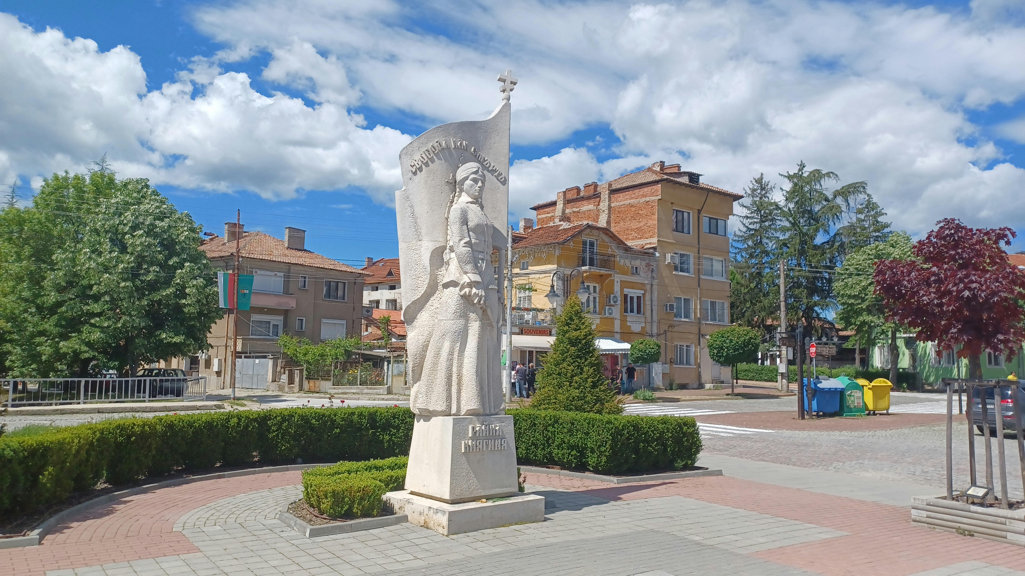 Statue Centered in a Sunlit Town Square with Historic Buildings