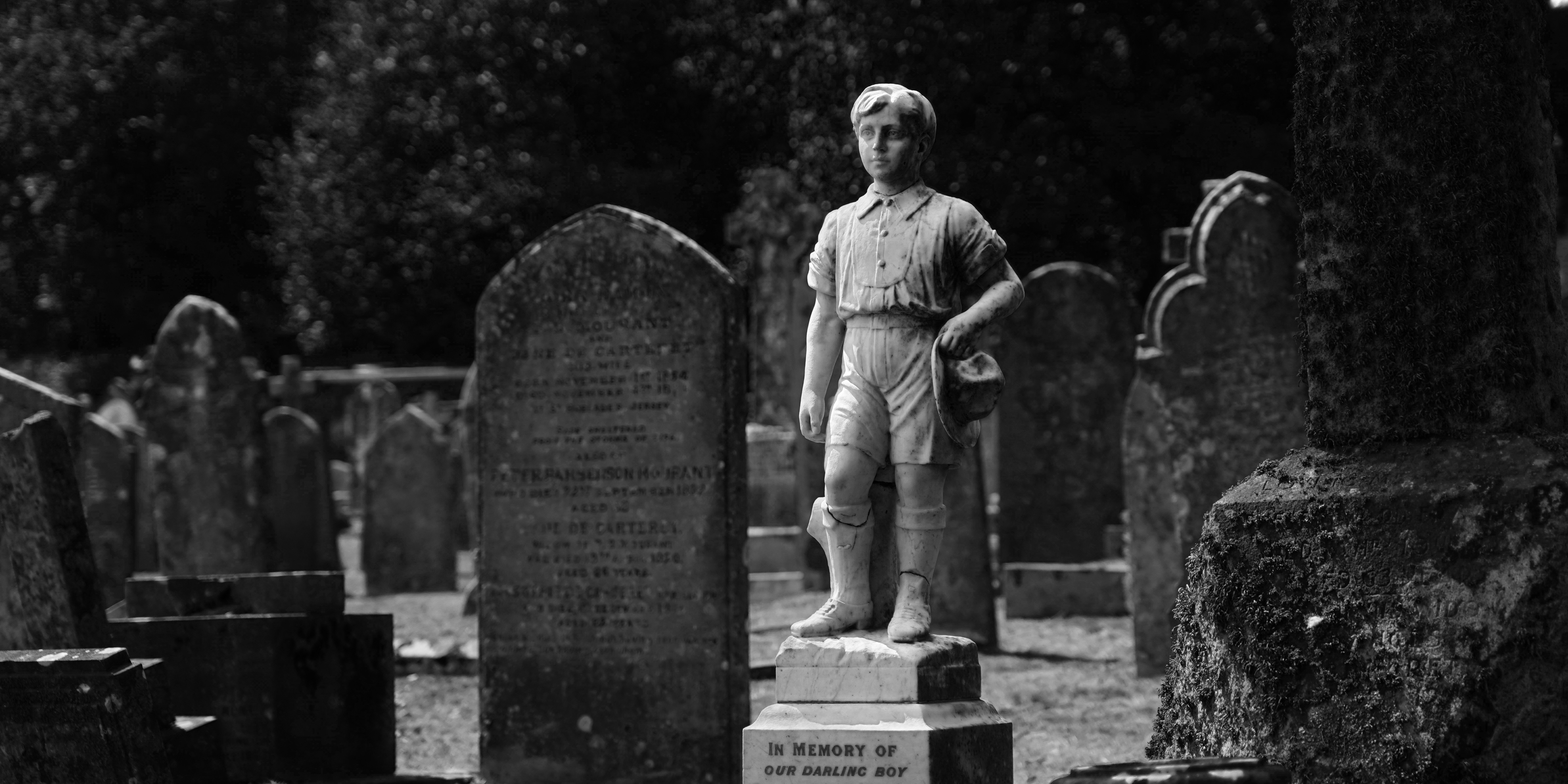 Silent Sentinel: A Child Statue Overlooking the Graveyard