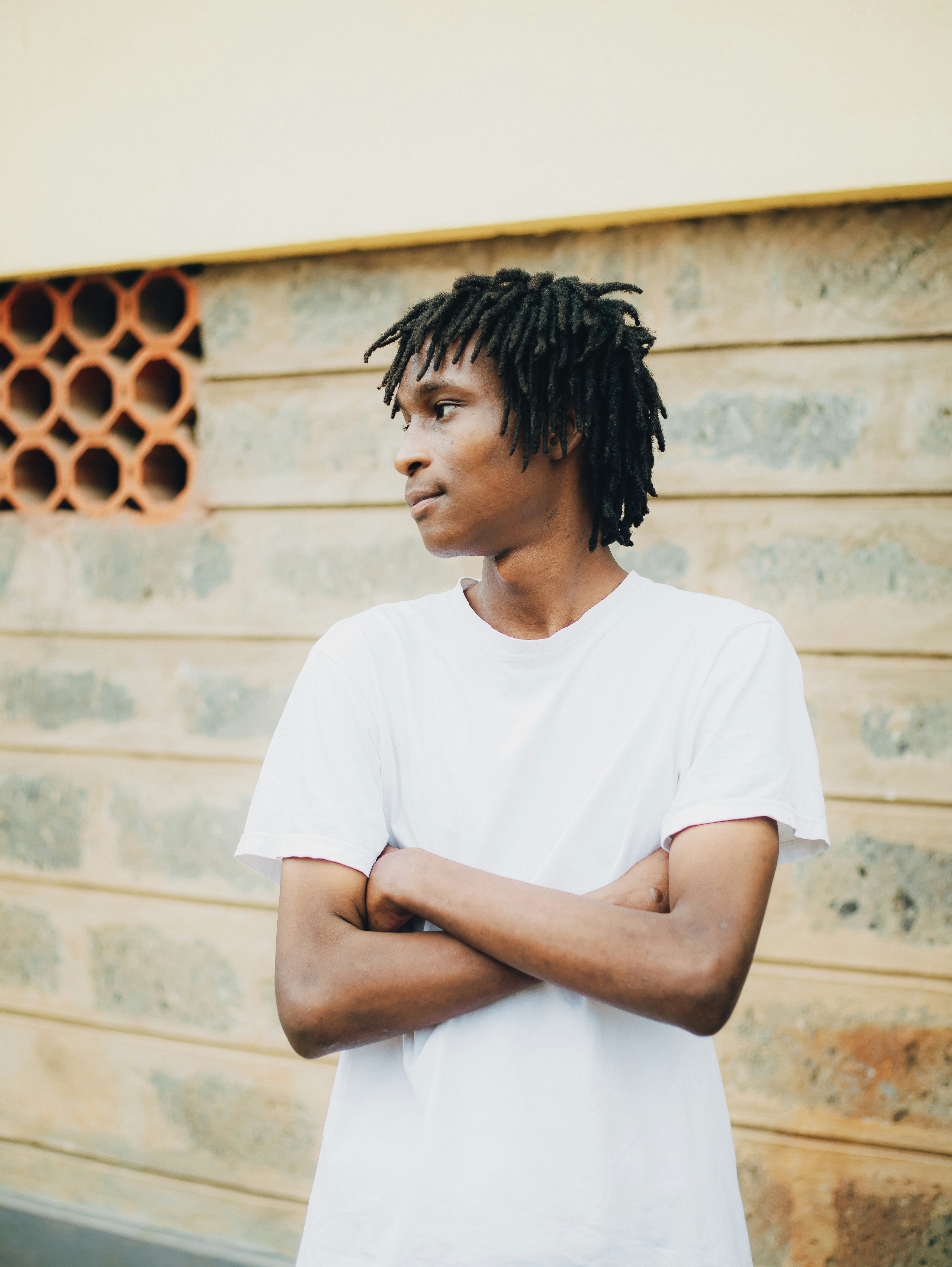 Portrait of Resolve: A Youthful Gaze Against a Textured Wall