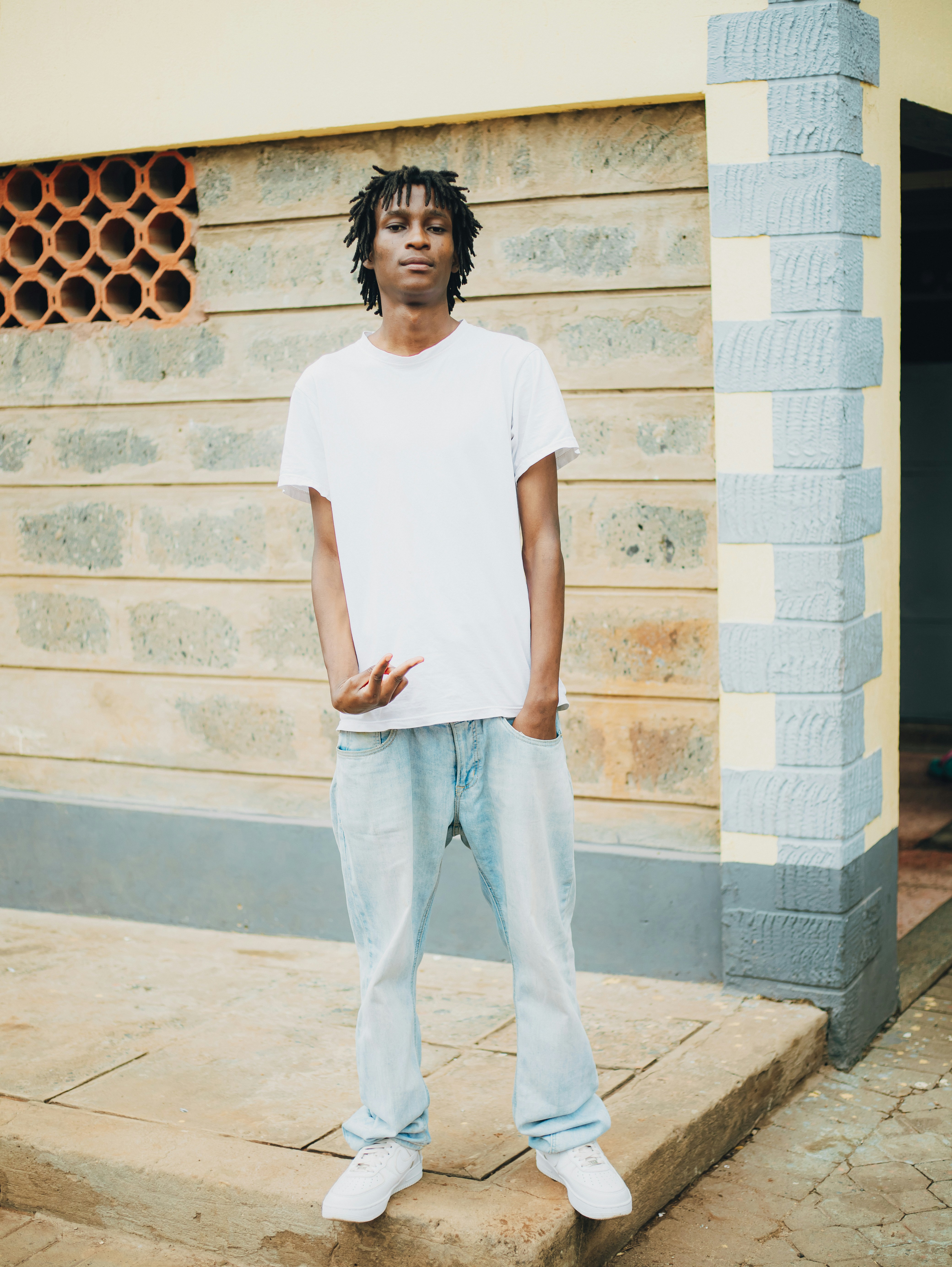 Youthful Stance Against a Textured Wall