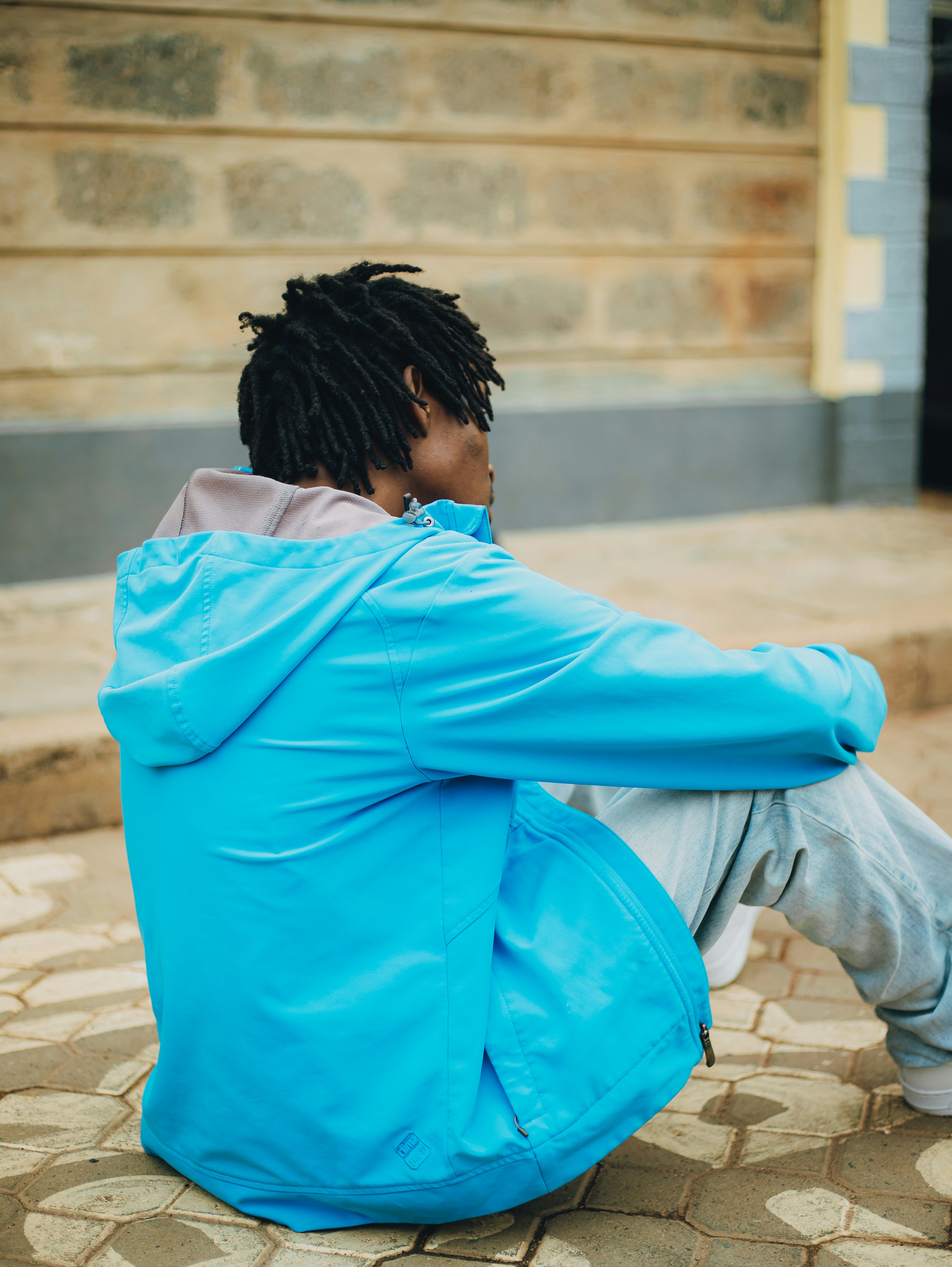 Blue Jacket, Quiet Ground: A Solitary Moment in Neon City Light