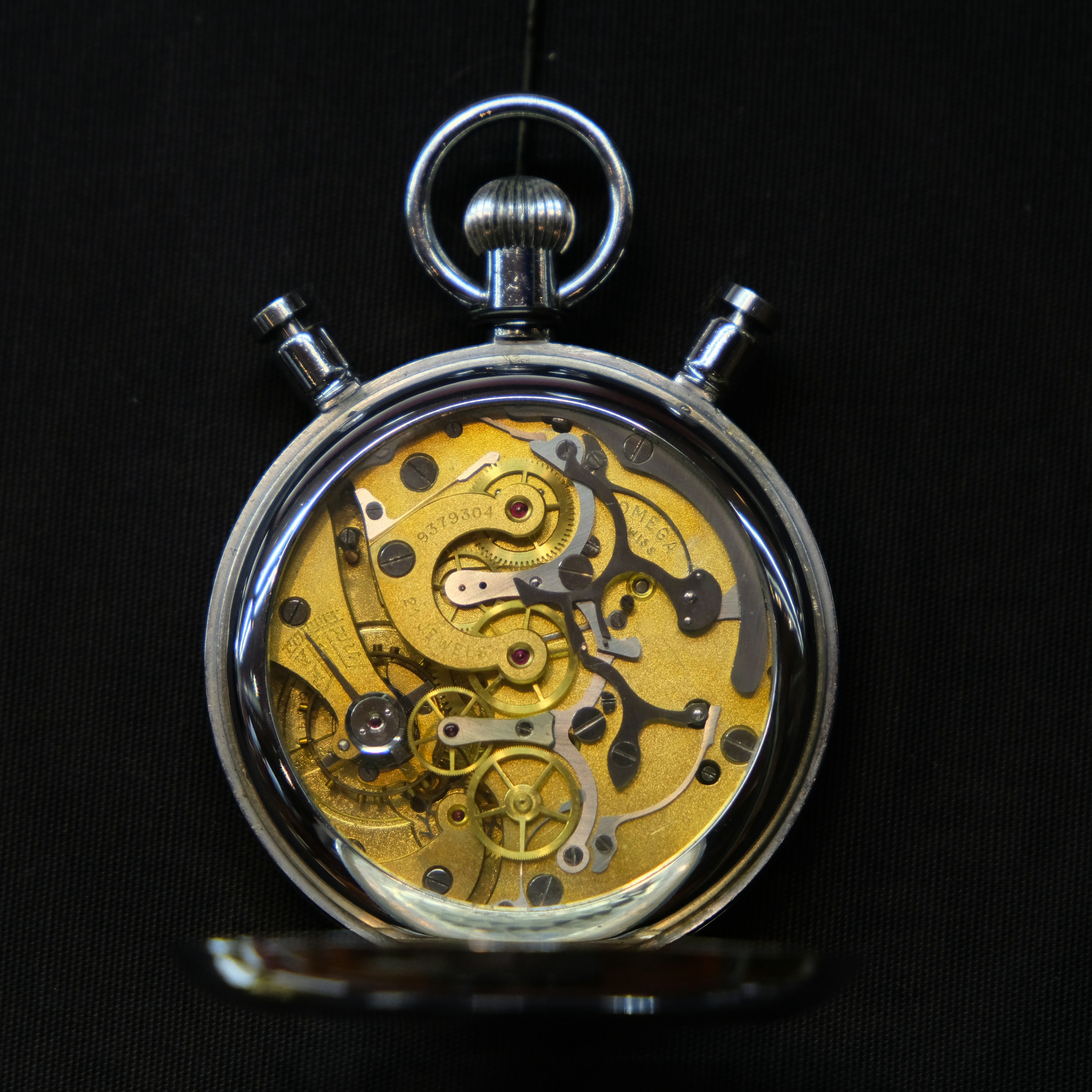 Golden gears in a silver pocket clock: a close-up of intricate mechanics