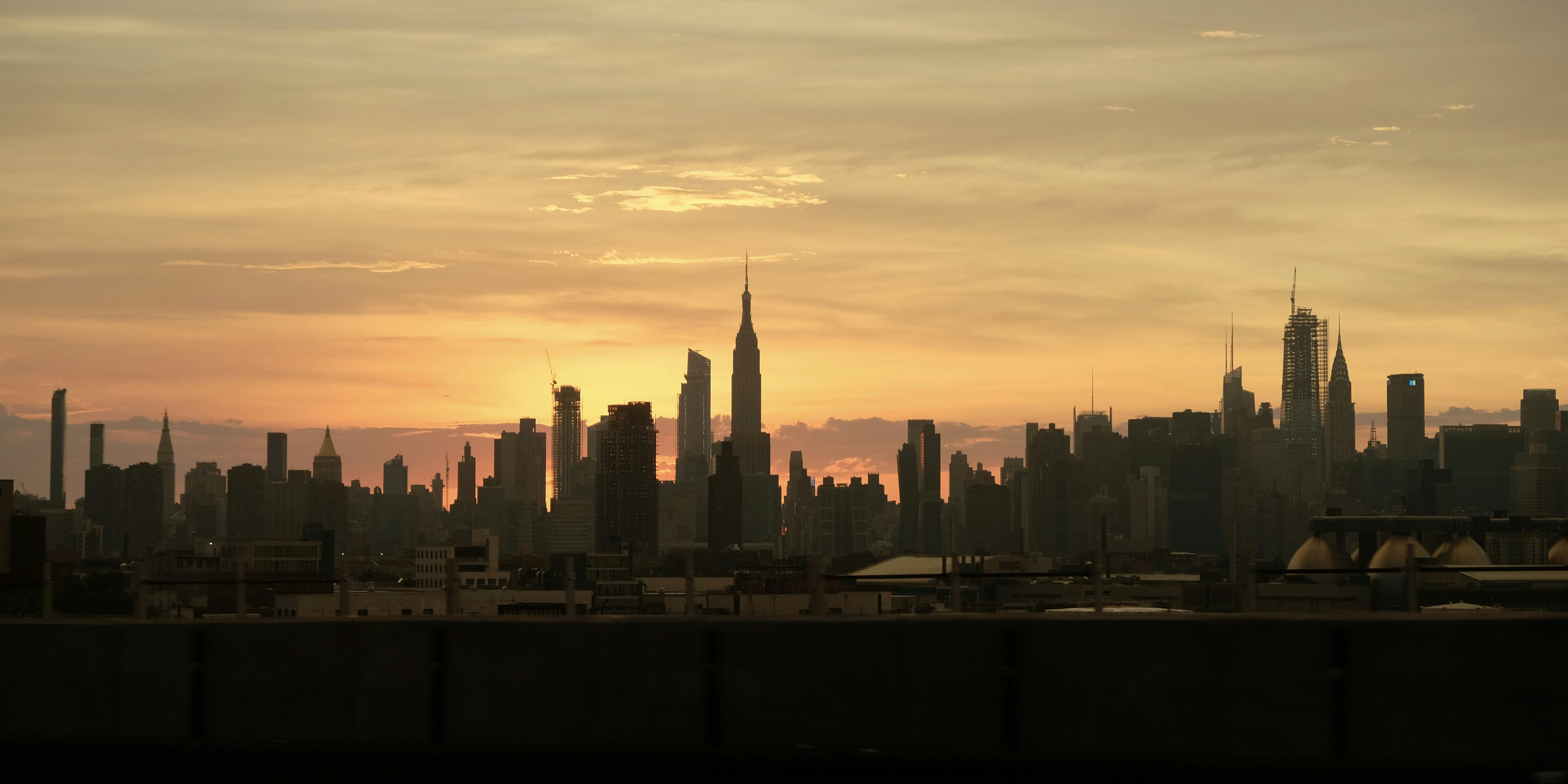 Dusk Over the River City: Silhouetted Skyline at Golden Hour