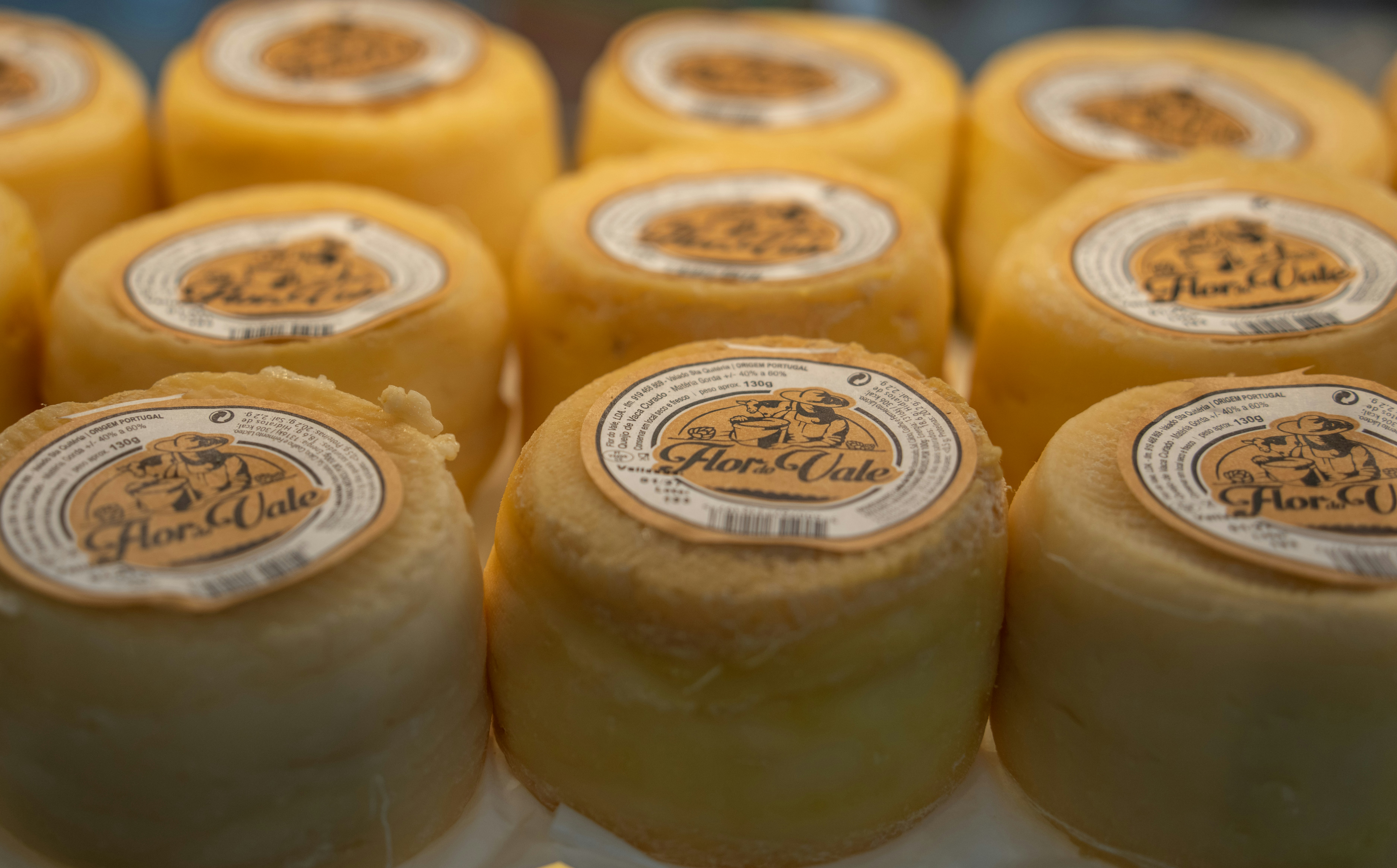 Golden Wheels: Close-Up of Cheese Grape? (Cheese Rounds) [Note: primary subject is the circular cheese wheels with labels]