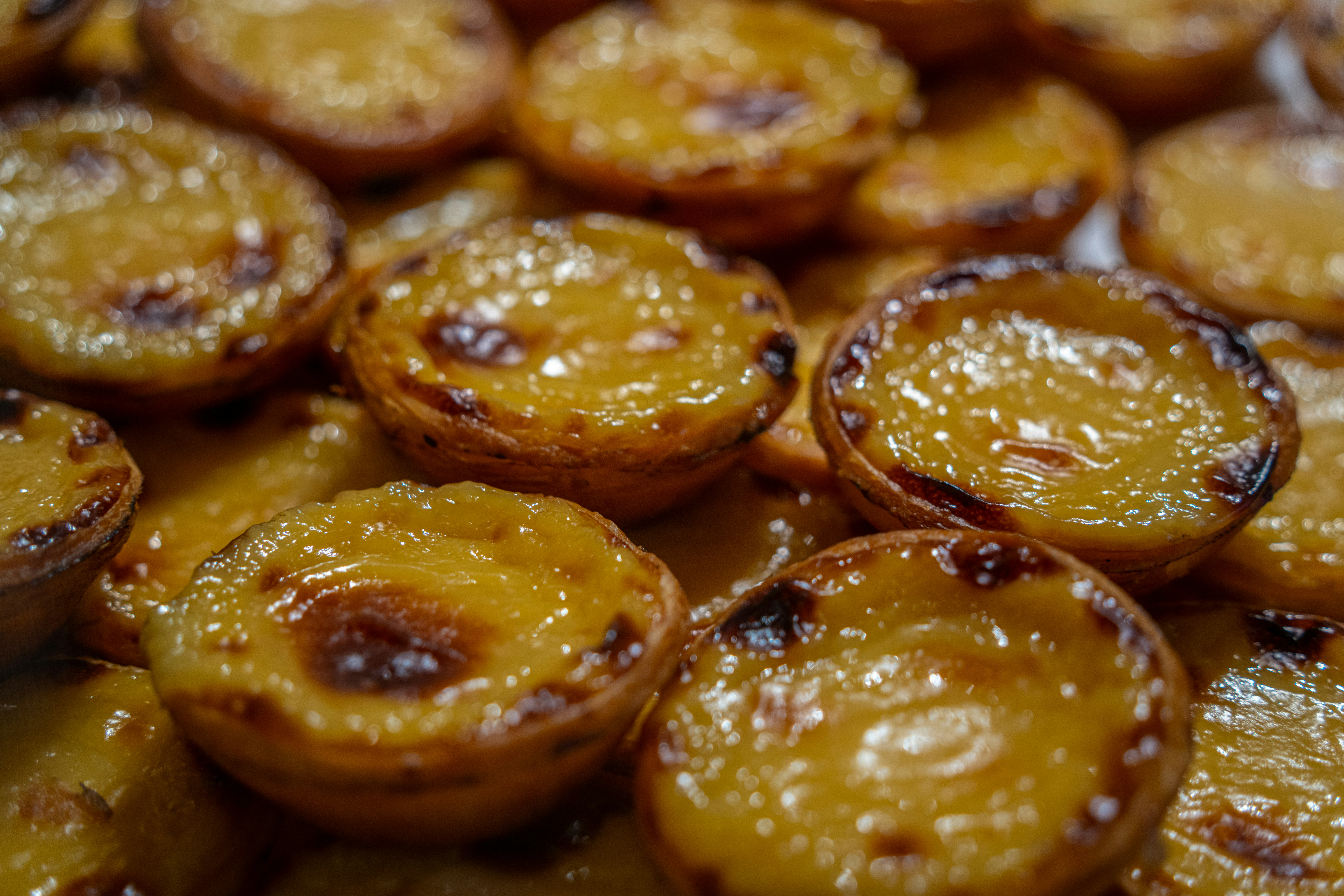 Golden Custards: Close-Up Portrait of Pasteis de Nata in a Crusty Stack