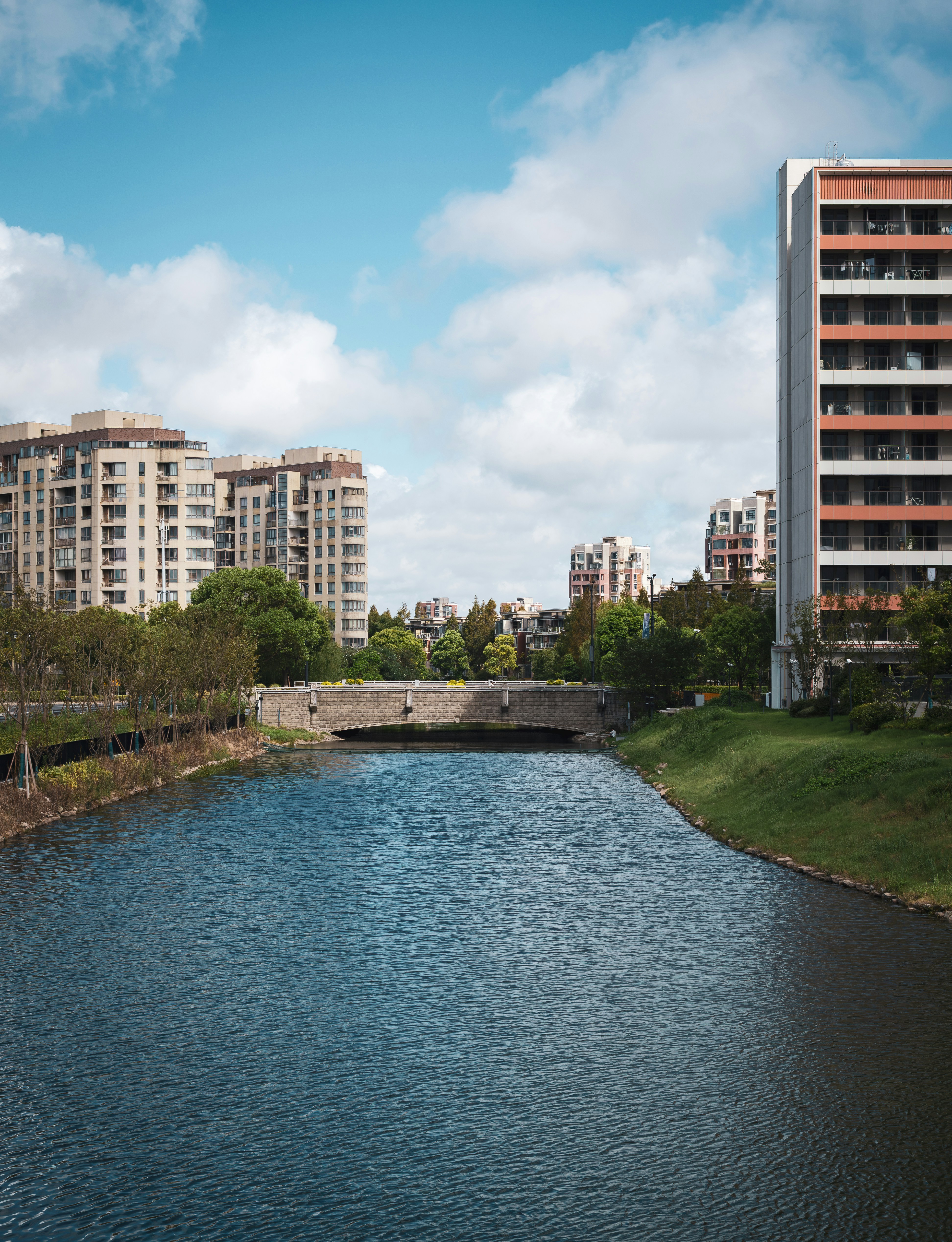 Urban Riverbend Under a Sky of Cushioned Clouds