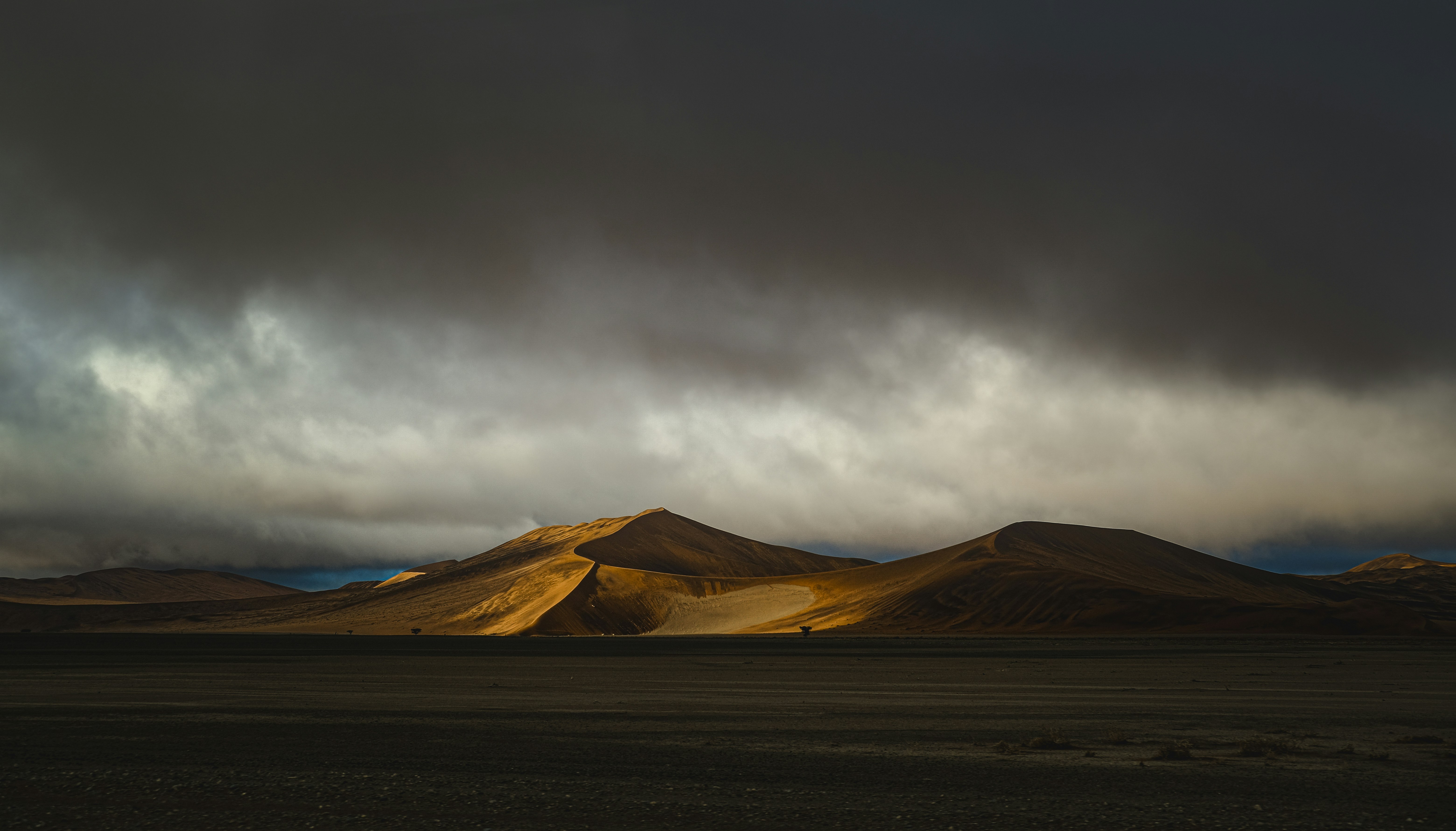 Golden Hills Beneath a Stormy Dome