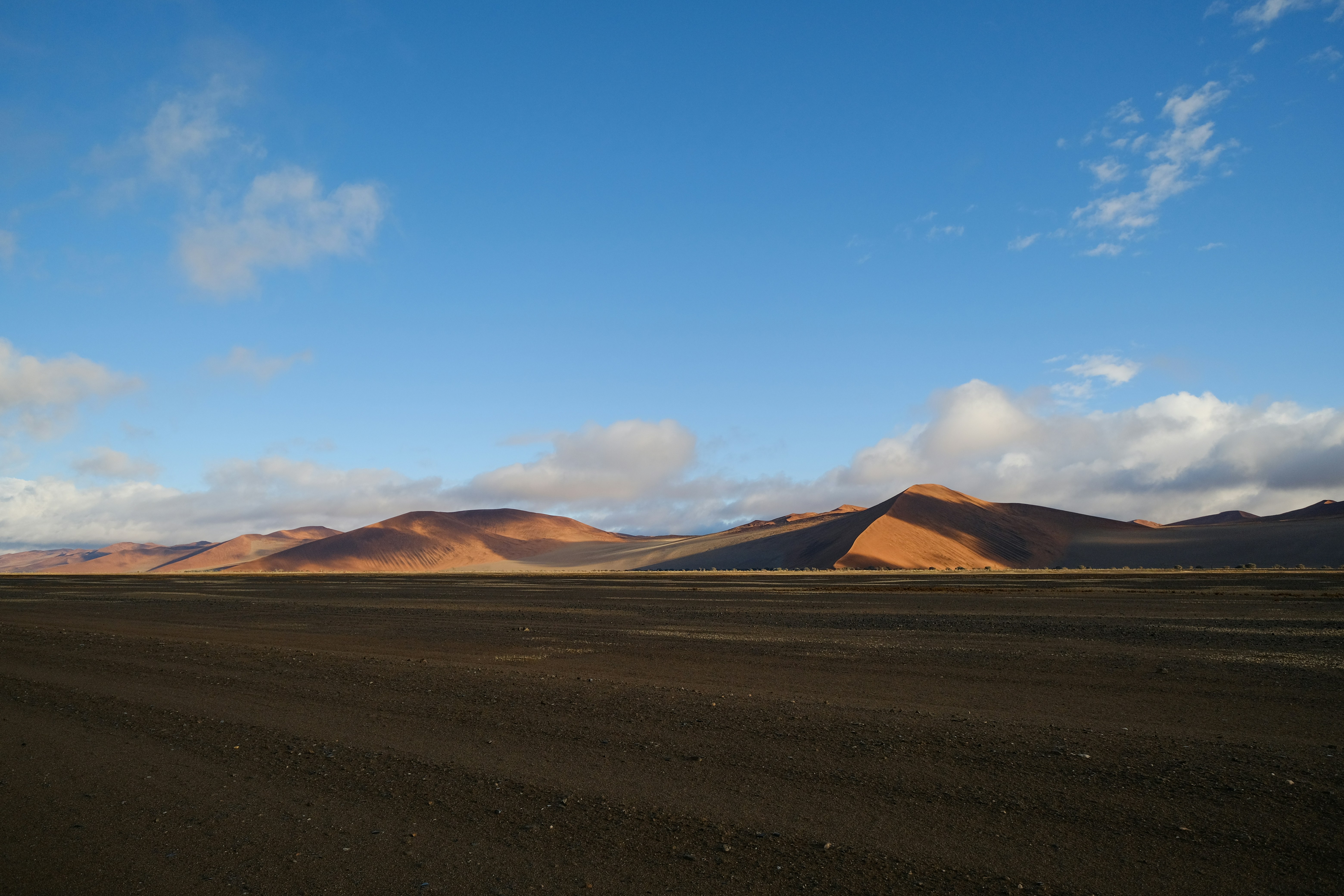 Lone Dune Windward: Sunlit Ridge Across a Flat, Desert Expanse