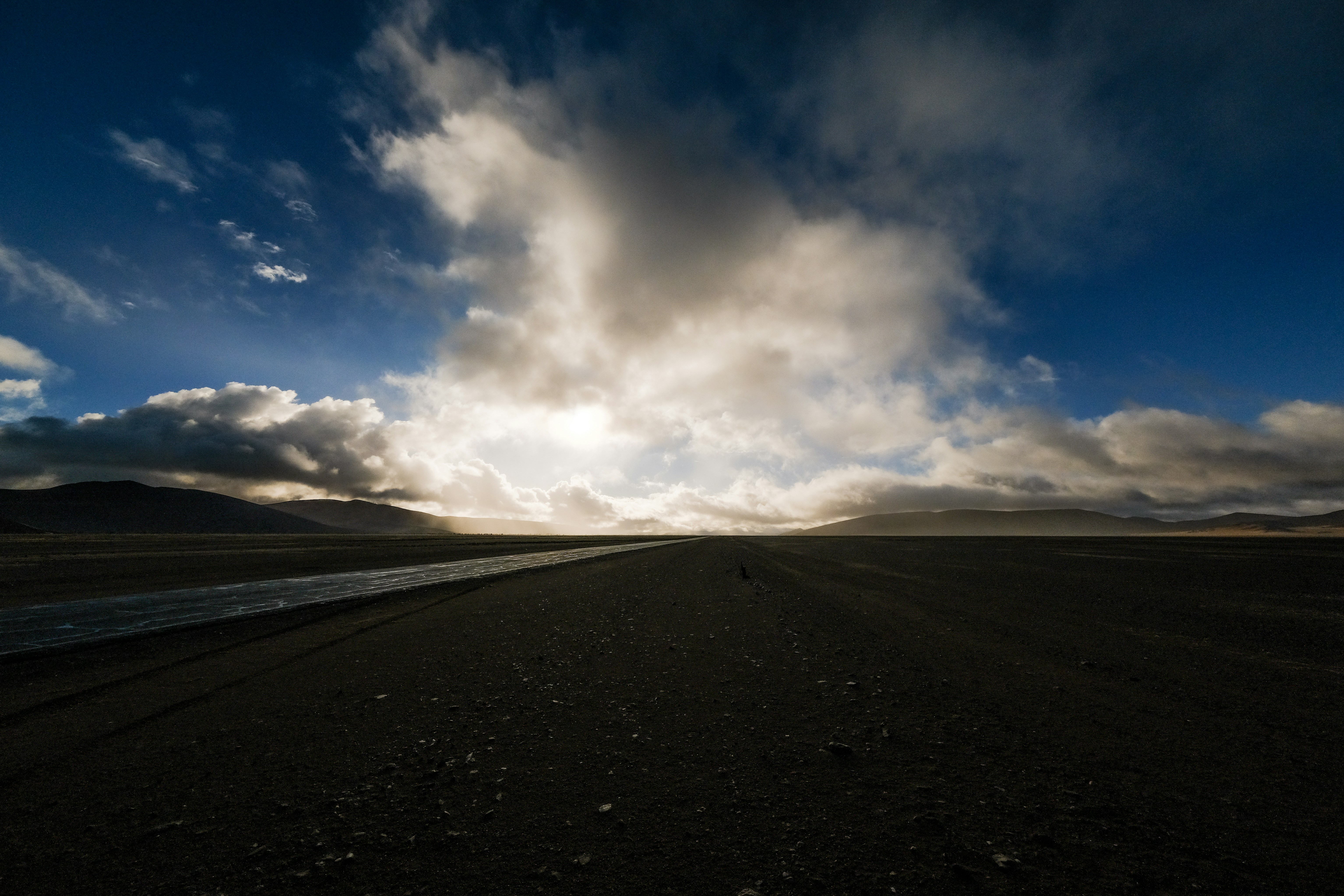 Sunlit Horizon Over a Dark Pebble Beach