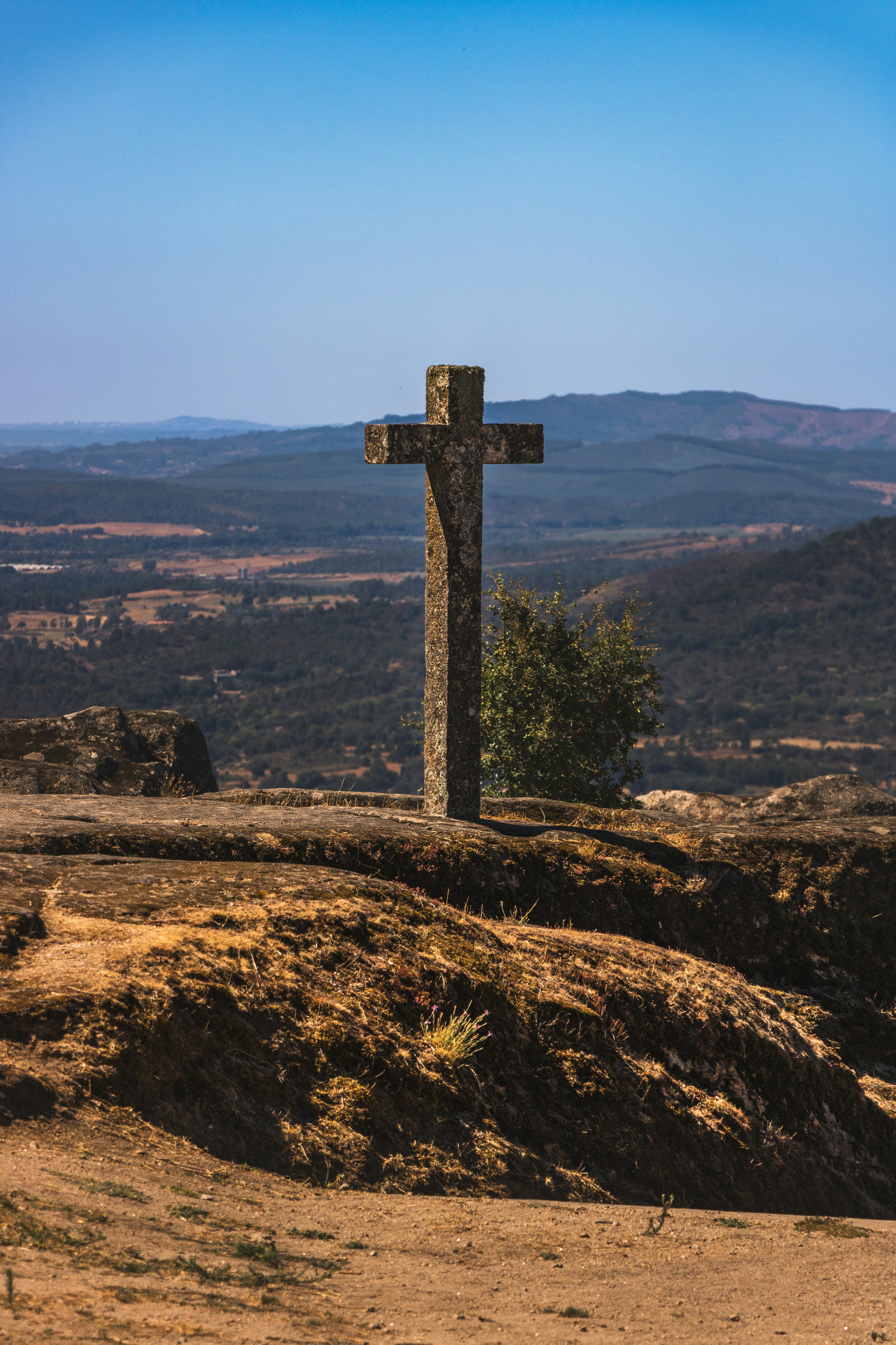 Stone Cross on a Hilltop Overlooking a Rolling Landscape