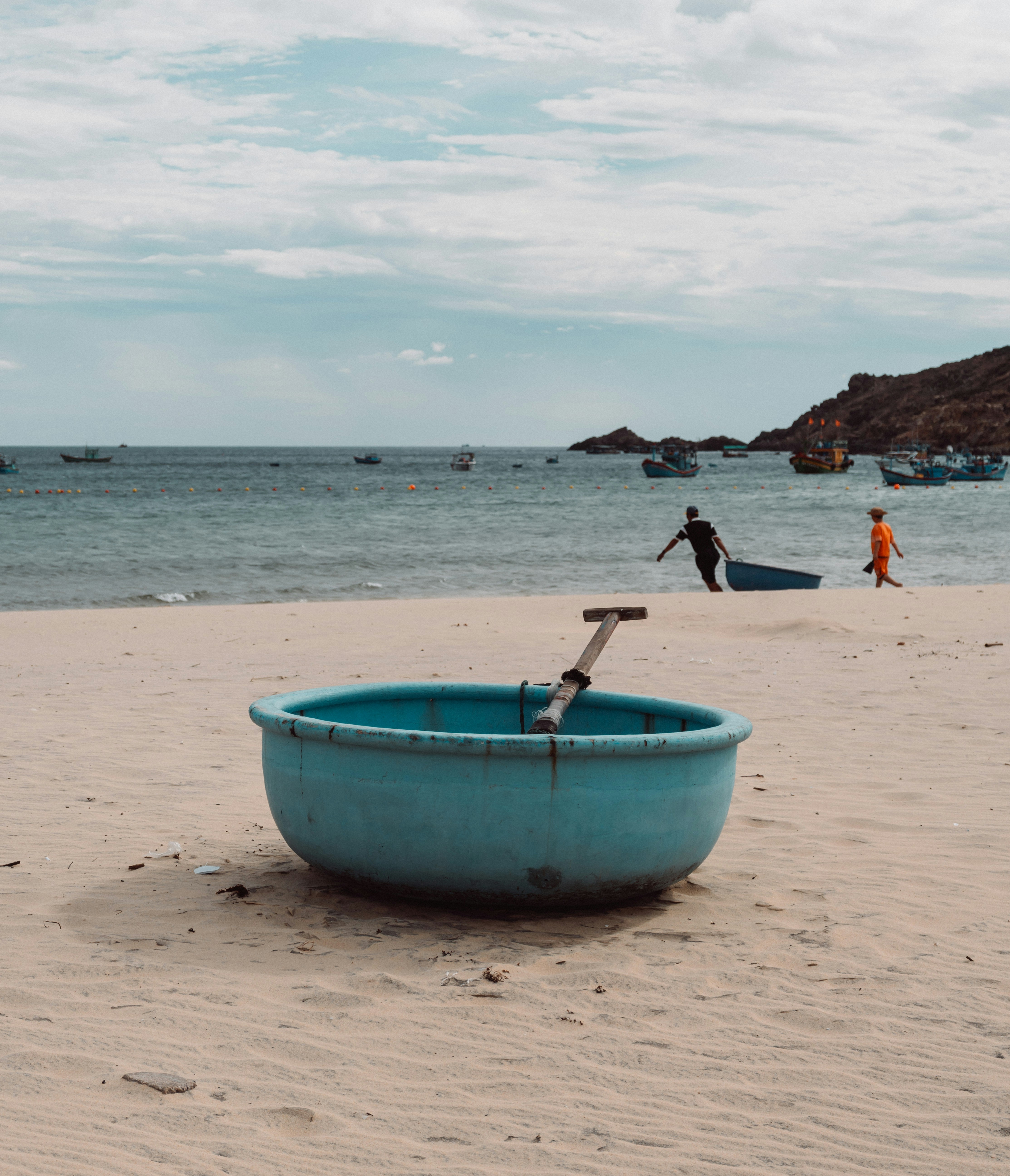 Blue Round Vessel Anchors a Quiet Beach Scene