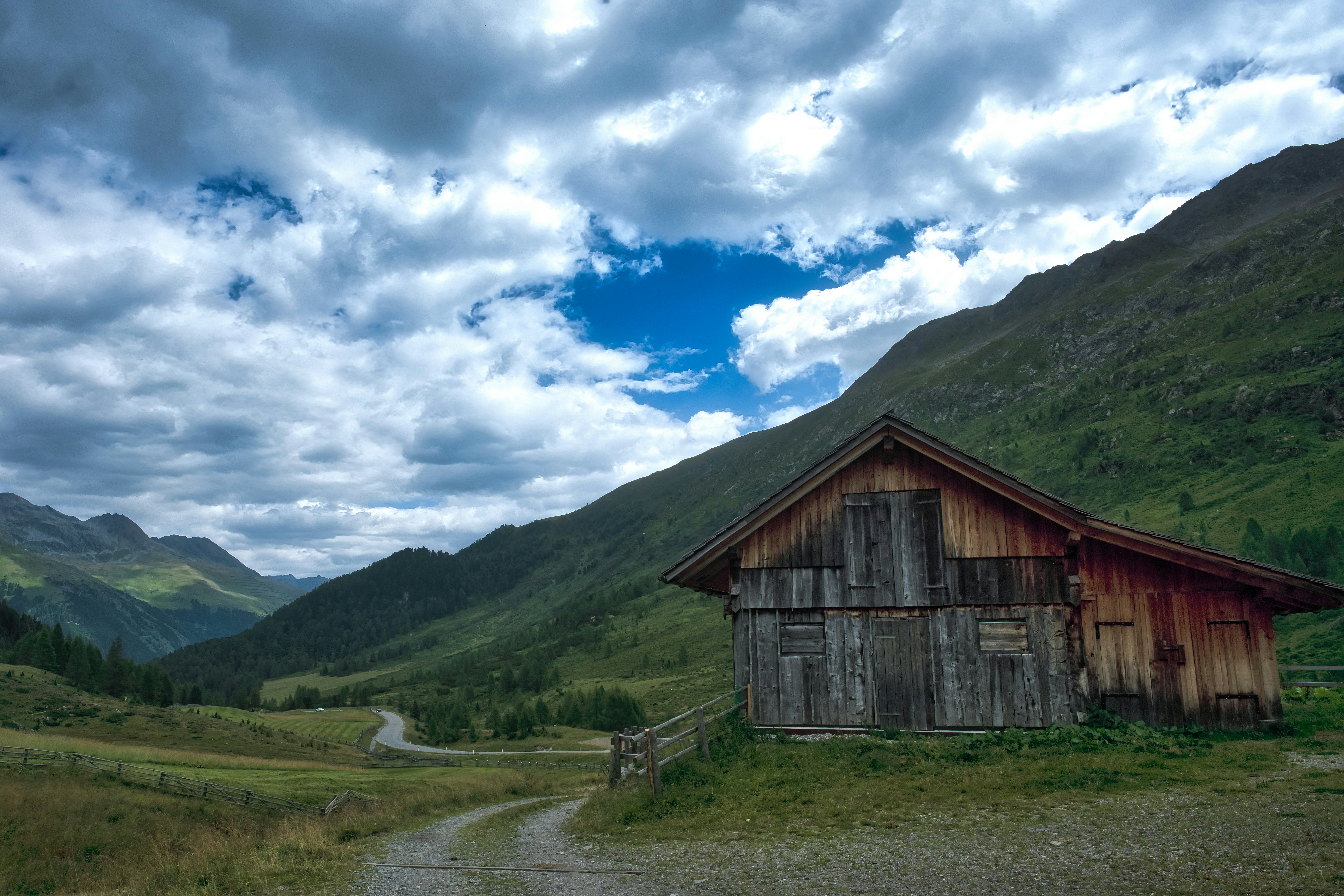 Weathered barn in a valley between alpine ridges