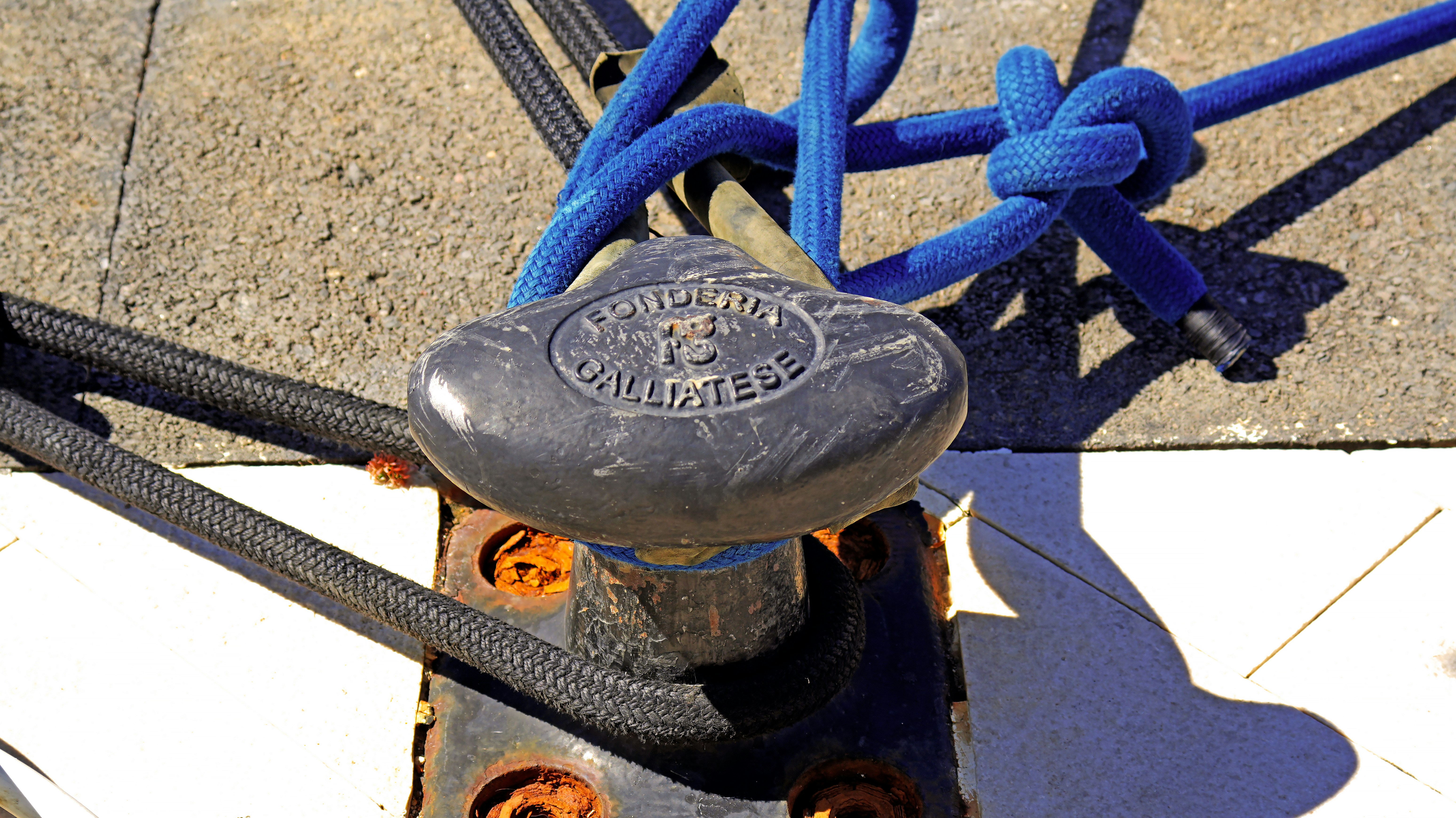 Dock Cleat and Coiled Rope under Bright Sun