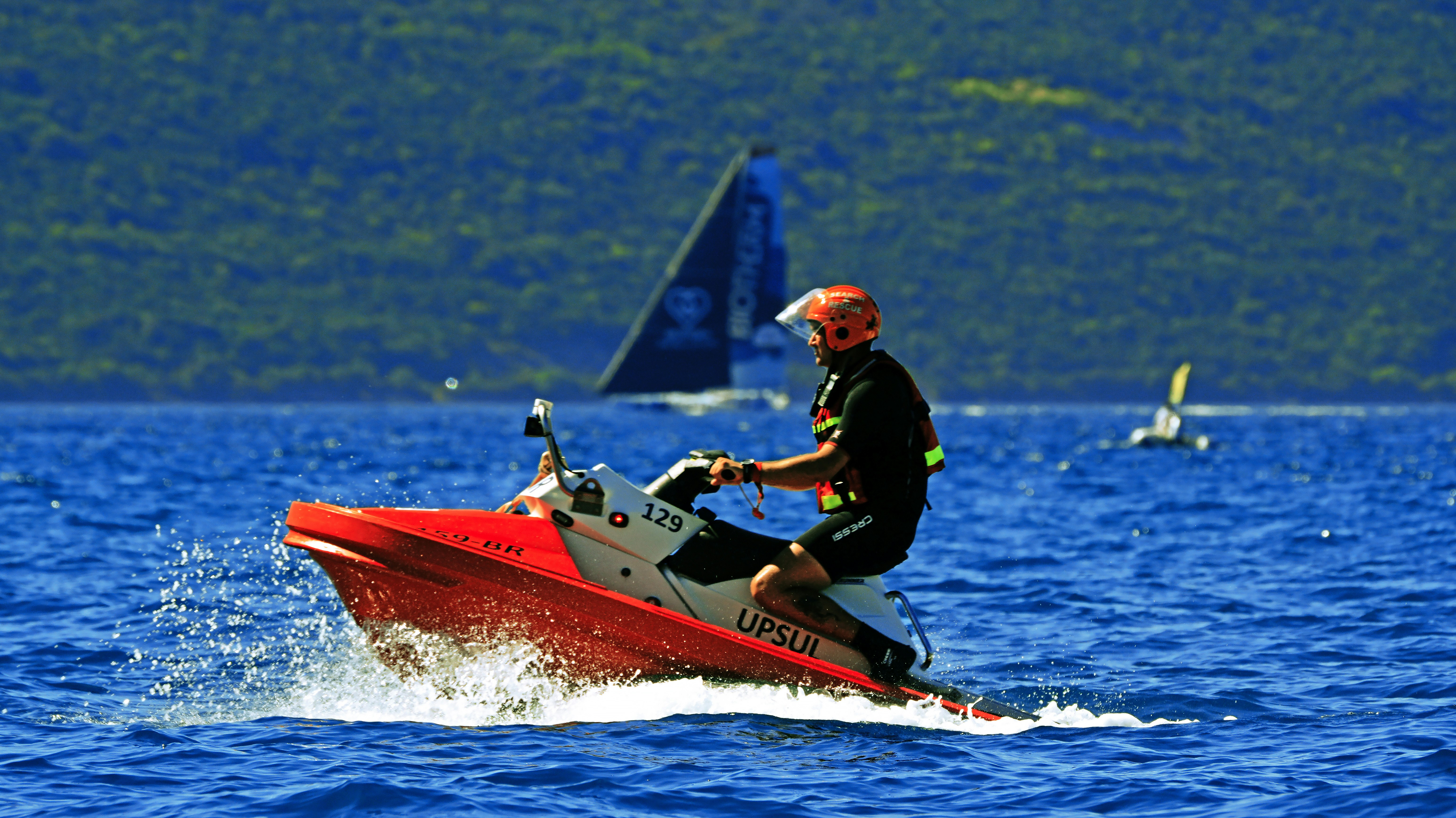Red Hydrodynamic Burst: Jet-Ski Rider in Bright Blue Waters