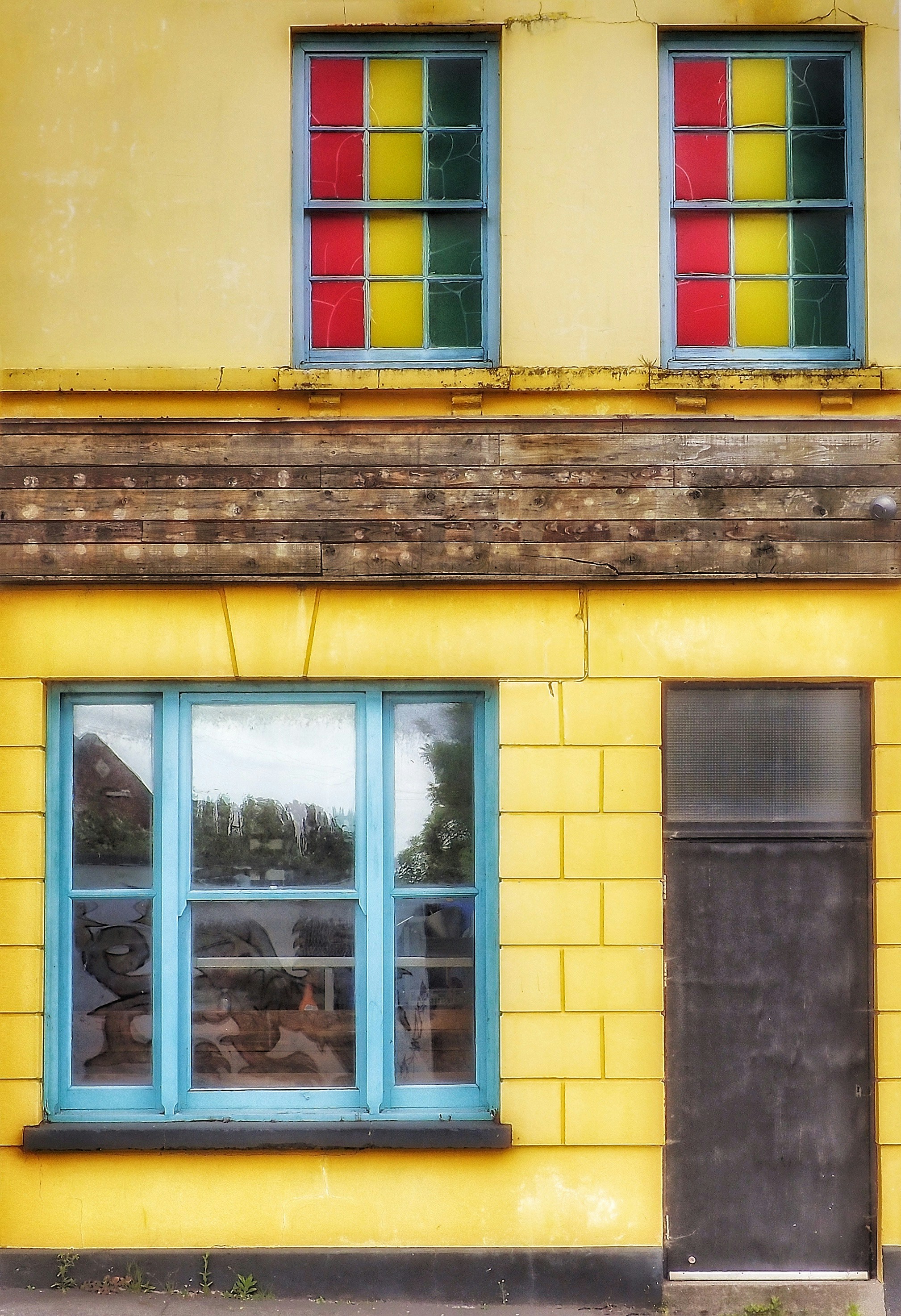 Yellow Facade with Blue Windows and Colorful Stained Upper Panes