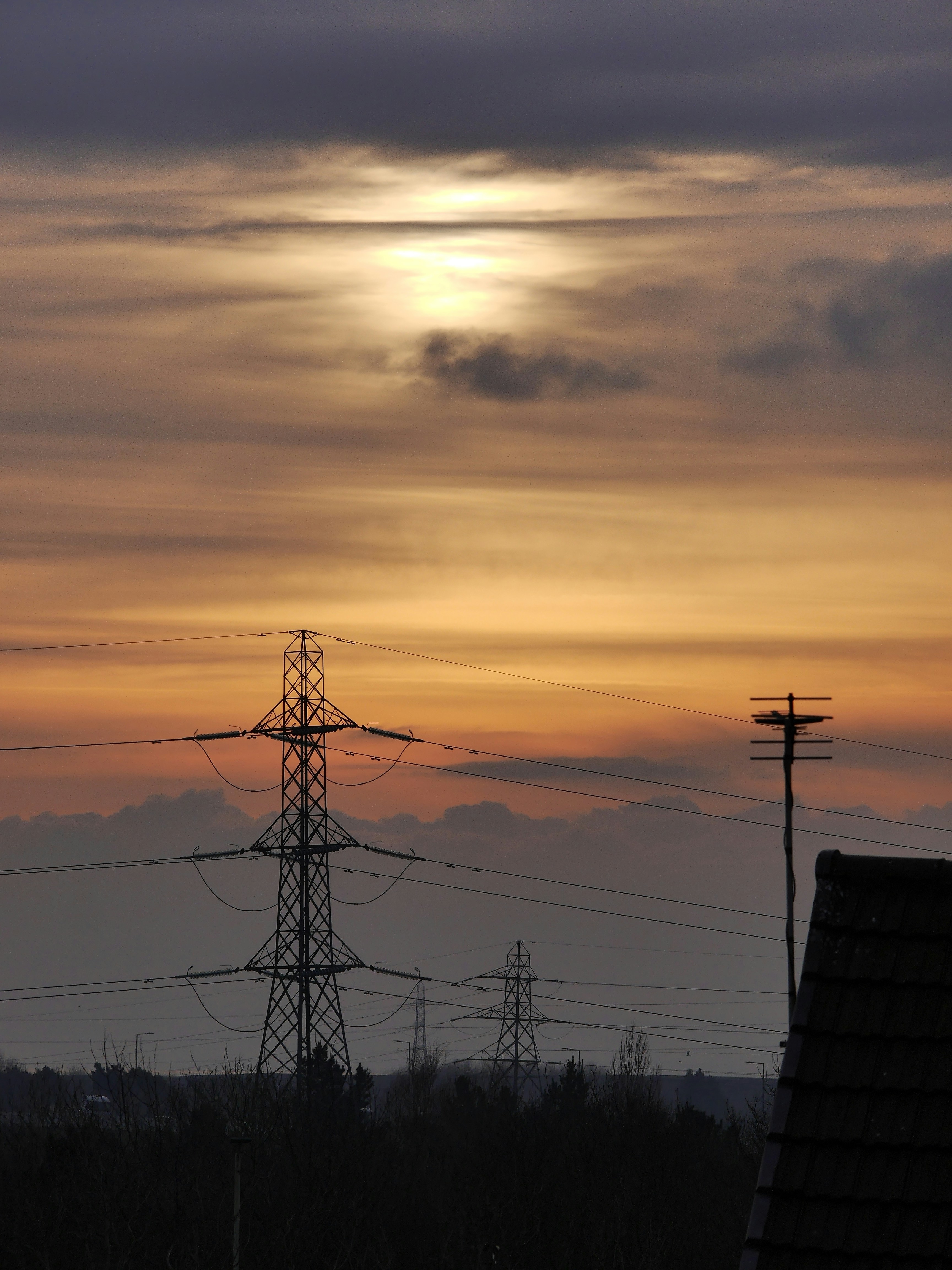 Sunset Over the Grid: silhouettes of towers against a fiery horizon