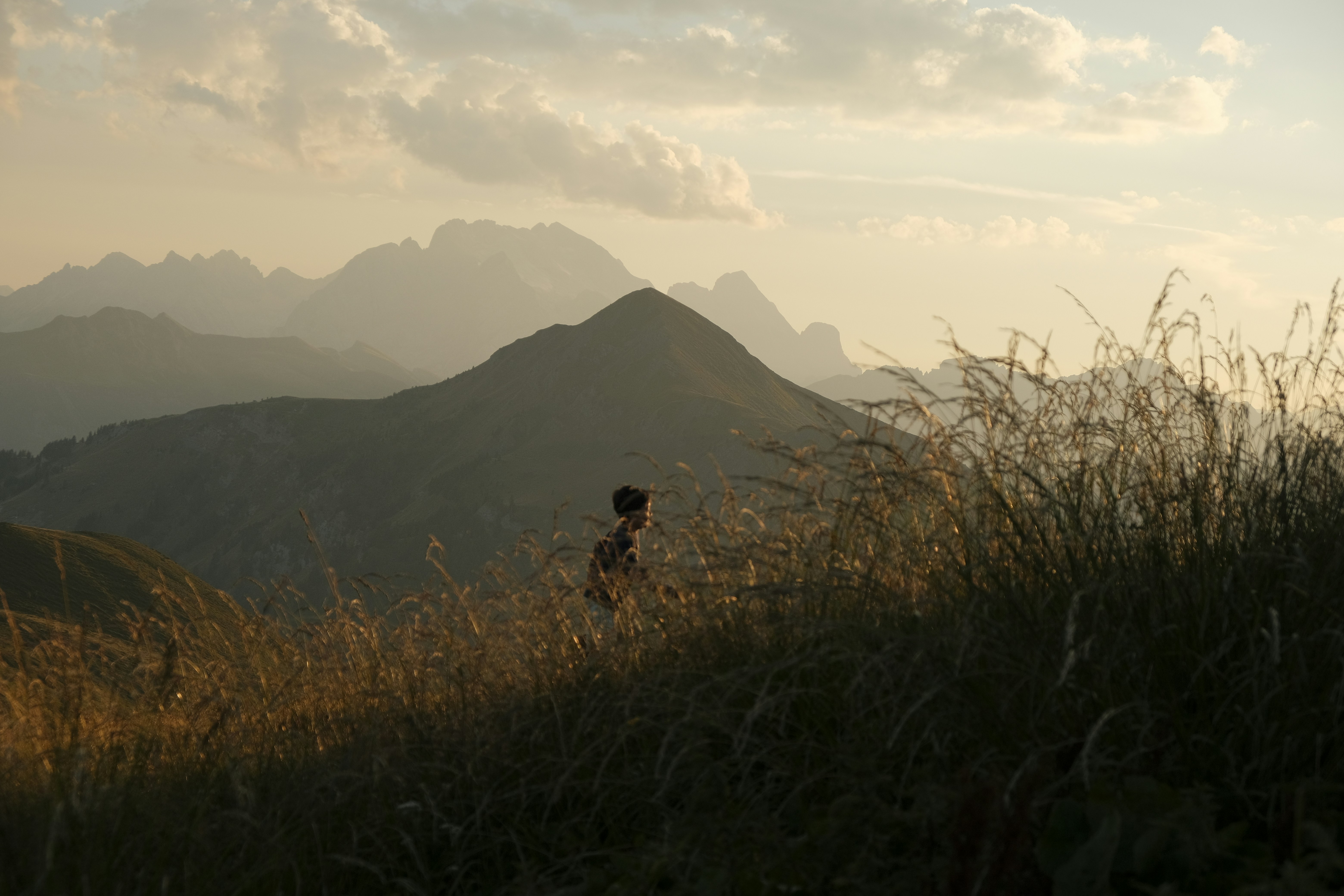 Quiet silhouette against a layered mountain horizon at golden hour