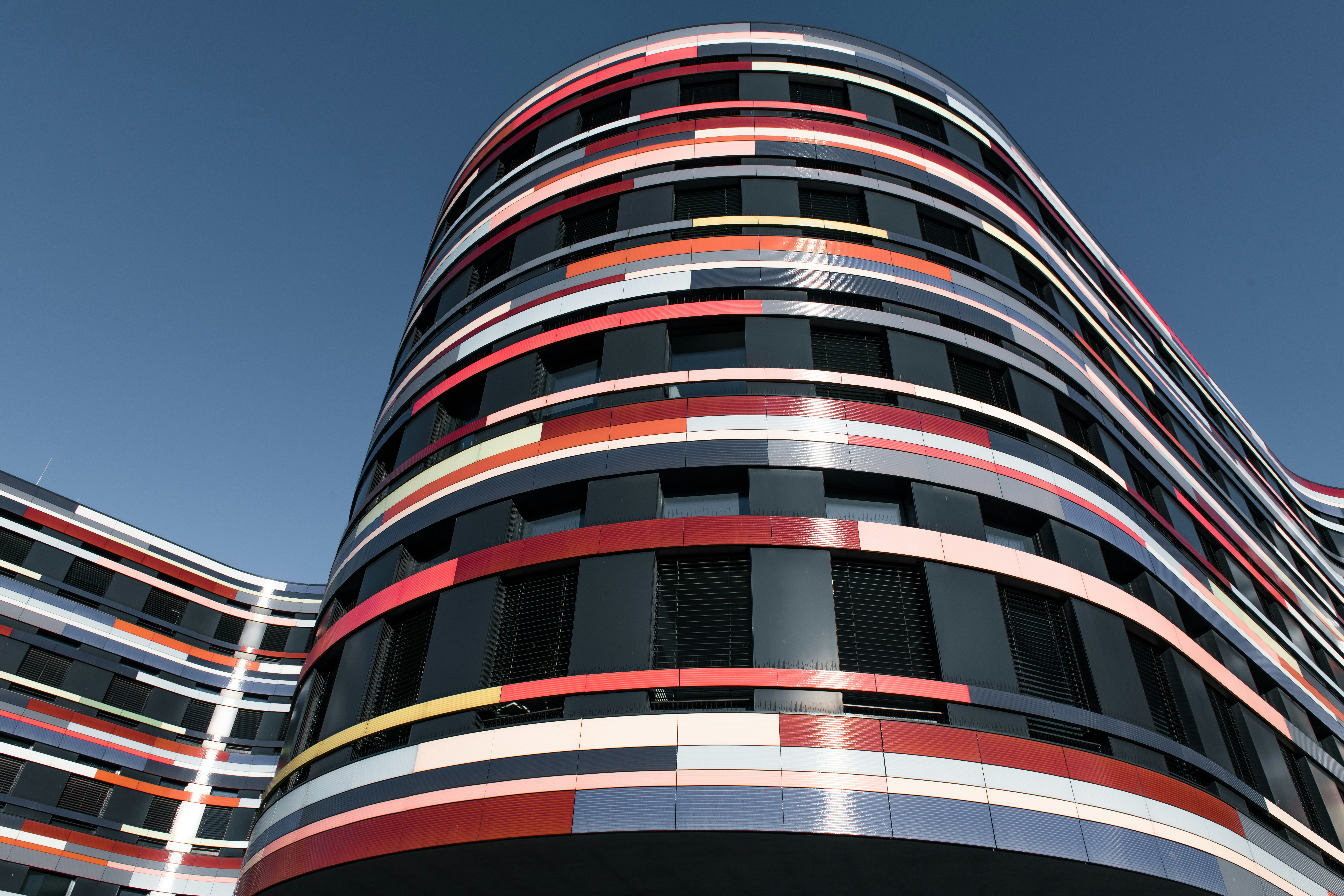 Curved Facade of Color-Striated Tower Reaching Toward the Sky