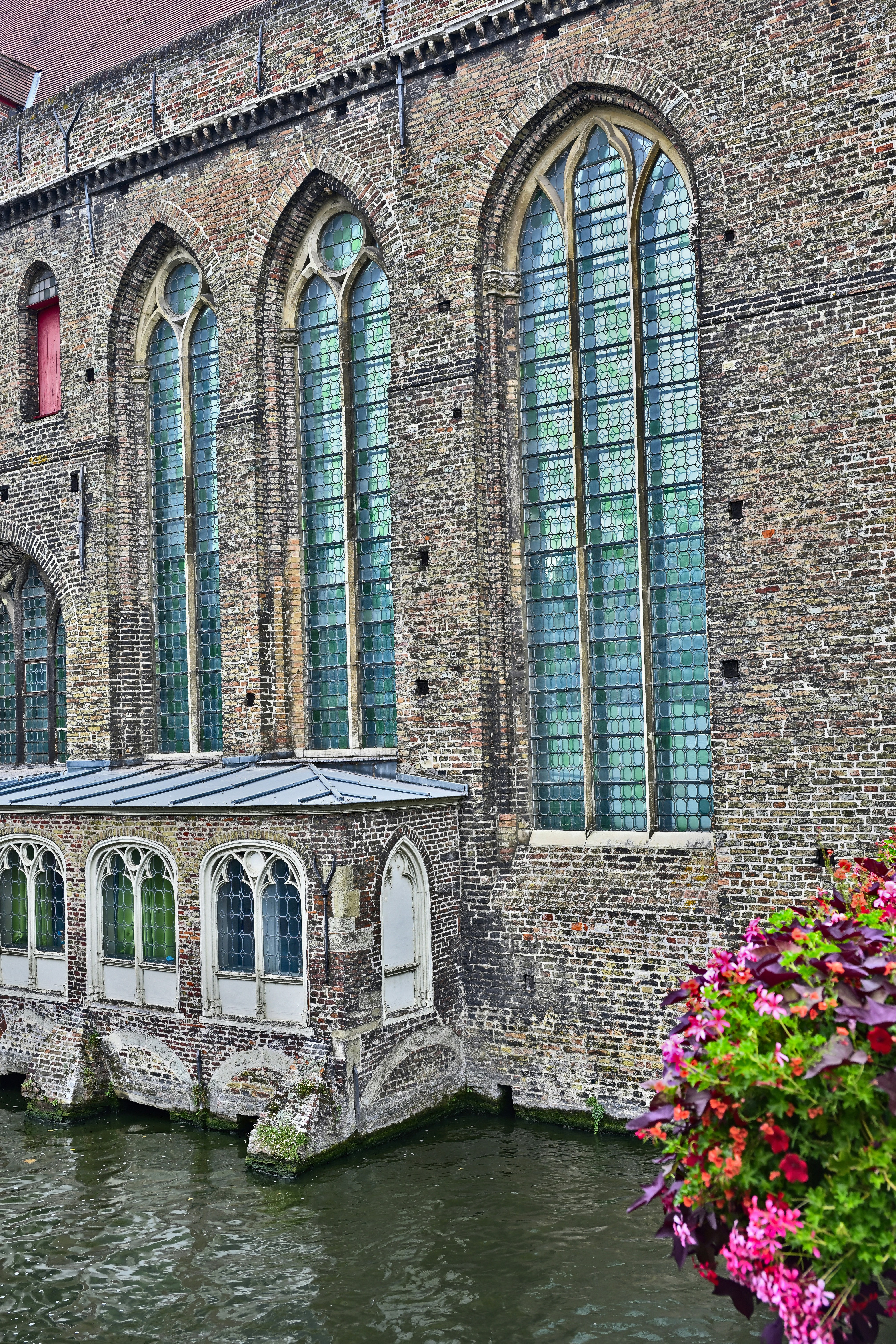 Gothic Riverhouse: A Brick Facade Framed by Stained Glass and Water