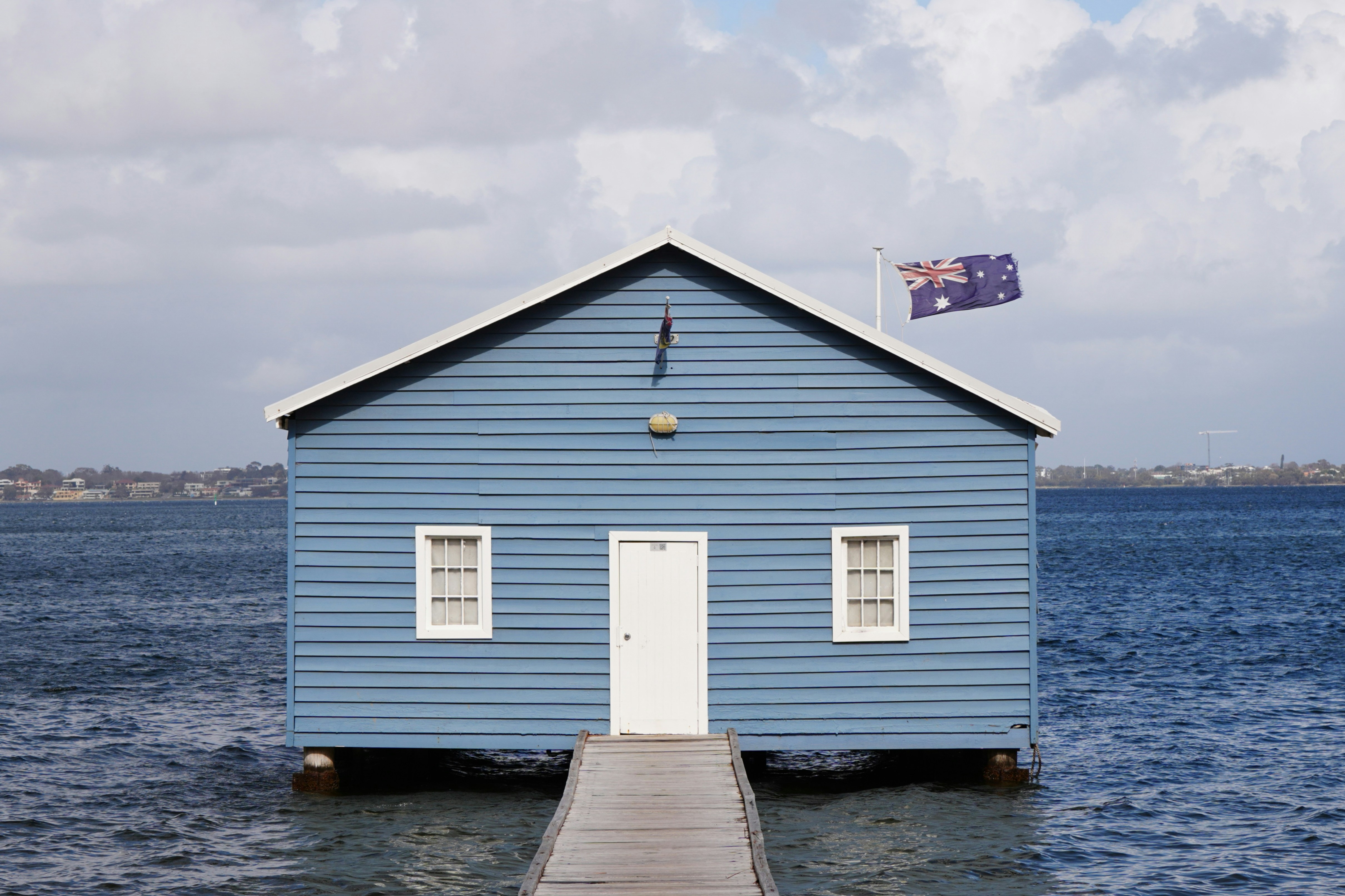 Blue Lakehouse Over Calm Waters with Australian Flag