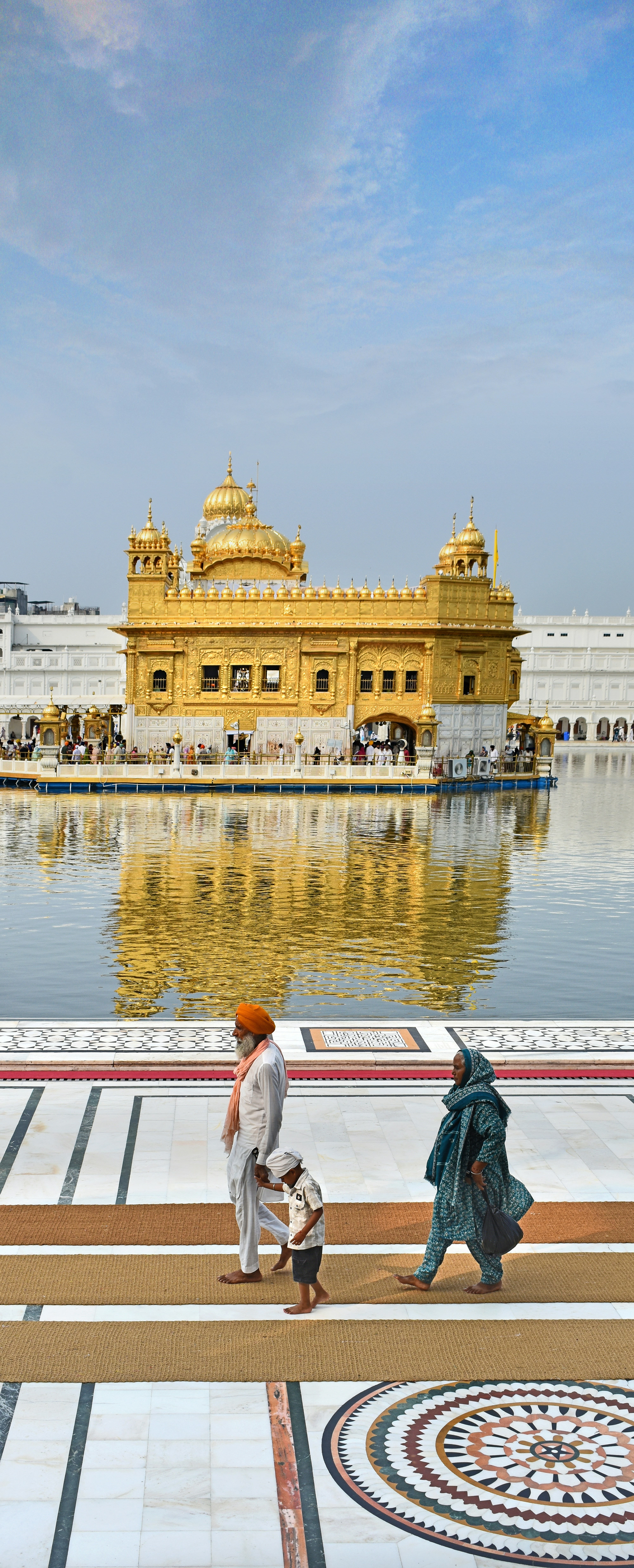 Golden Shrine Reflections: People Walk the Marble Rhythm by the Holy Pool
