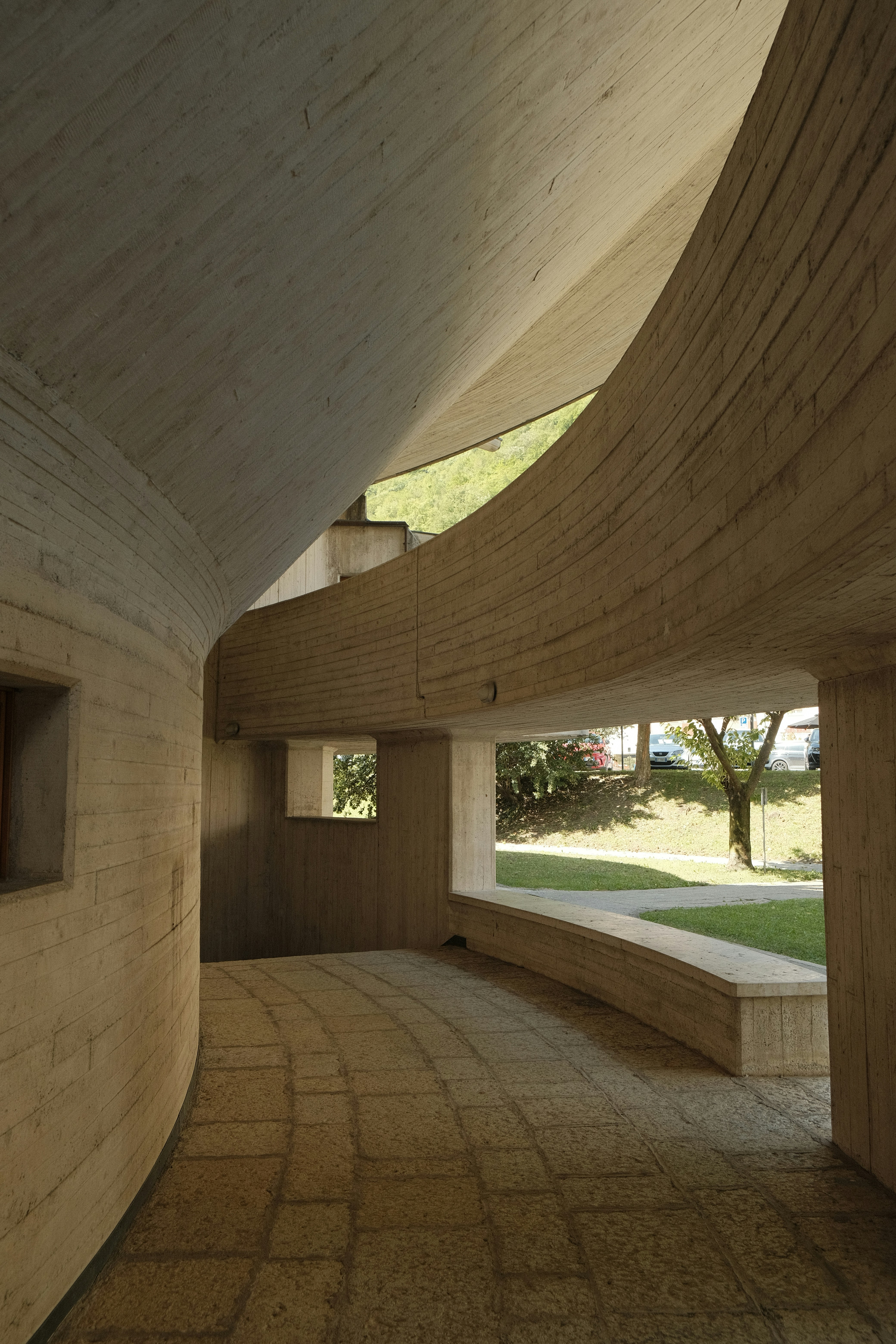 Curved Concrete Corridor: Light, Shadow, and a Path to Outside