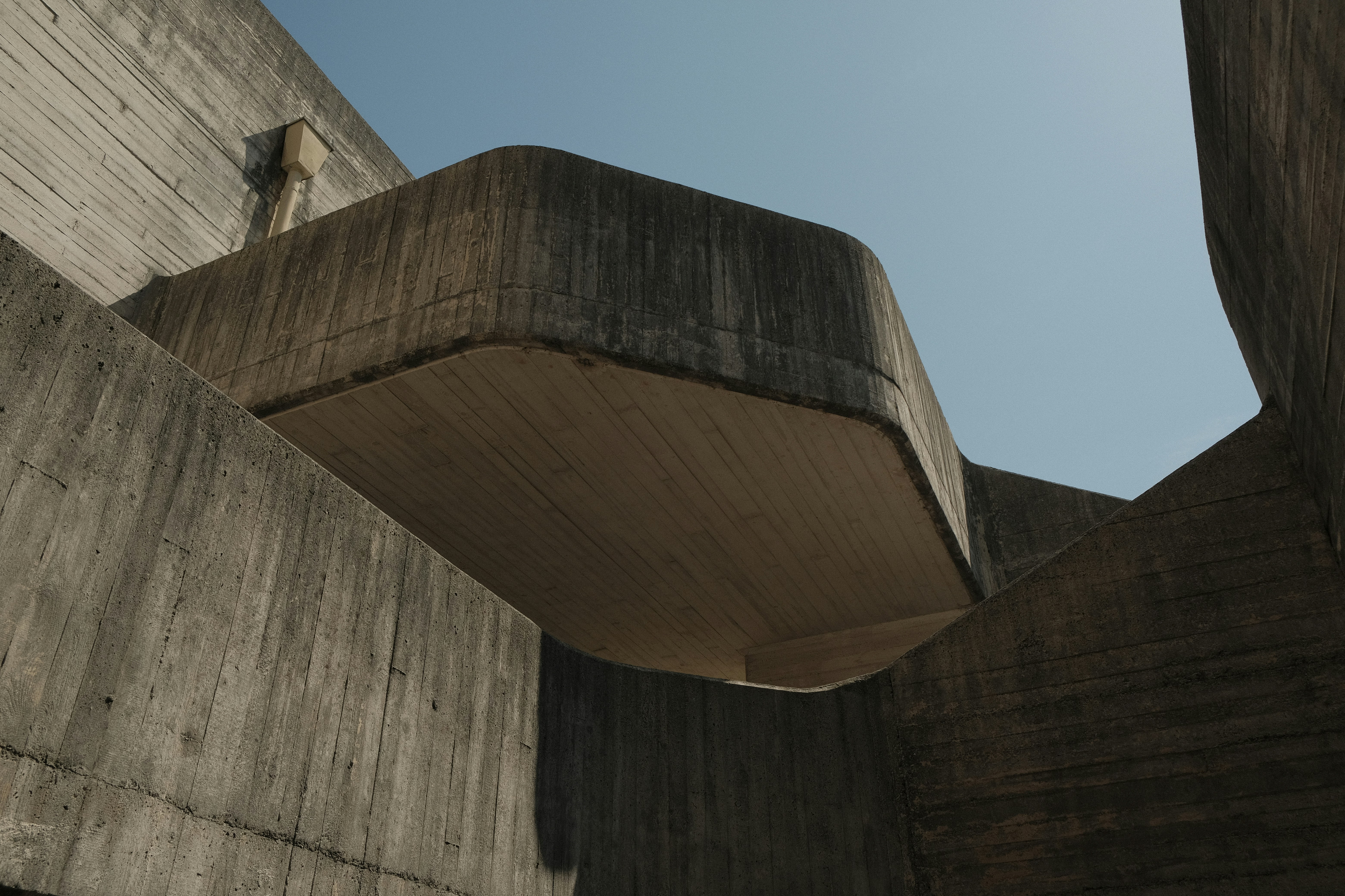 Brutalist Skywalk: Concrete Curves Against a Clear Blue